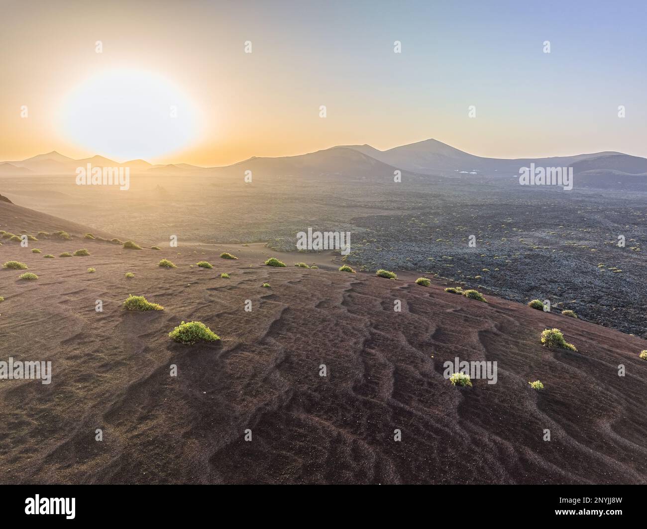 Wide Sunrise view of arid region of Lanzarote eroded by waves and ...