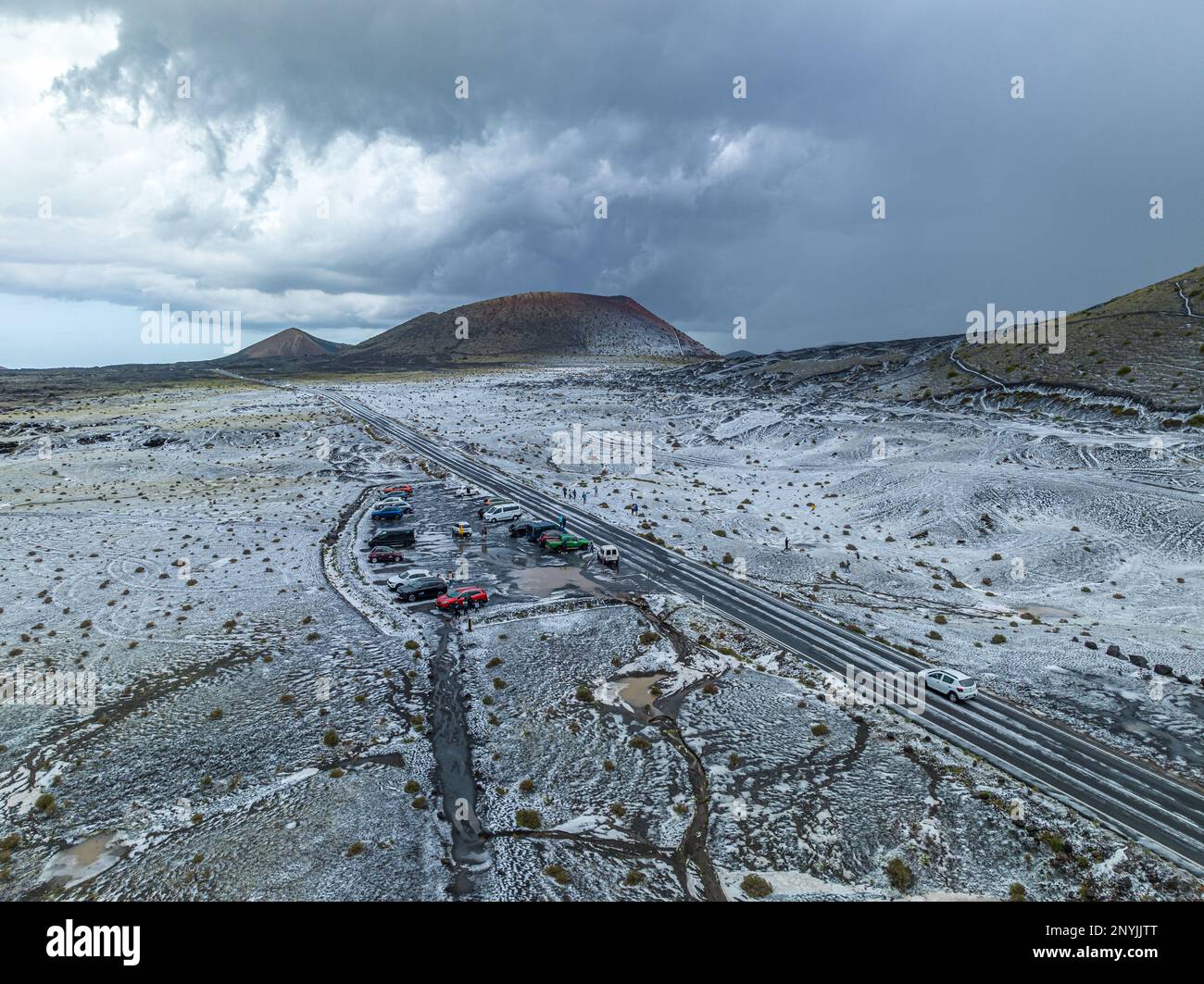 an aerial view caption a A snow-covered desert road meandering through ...