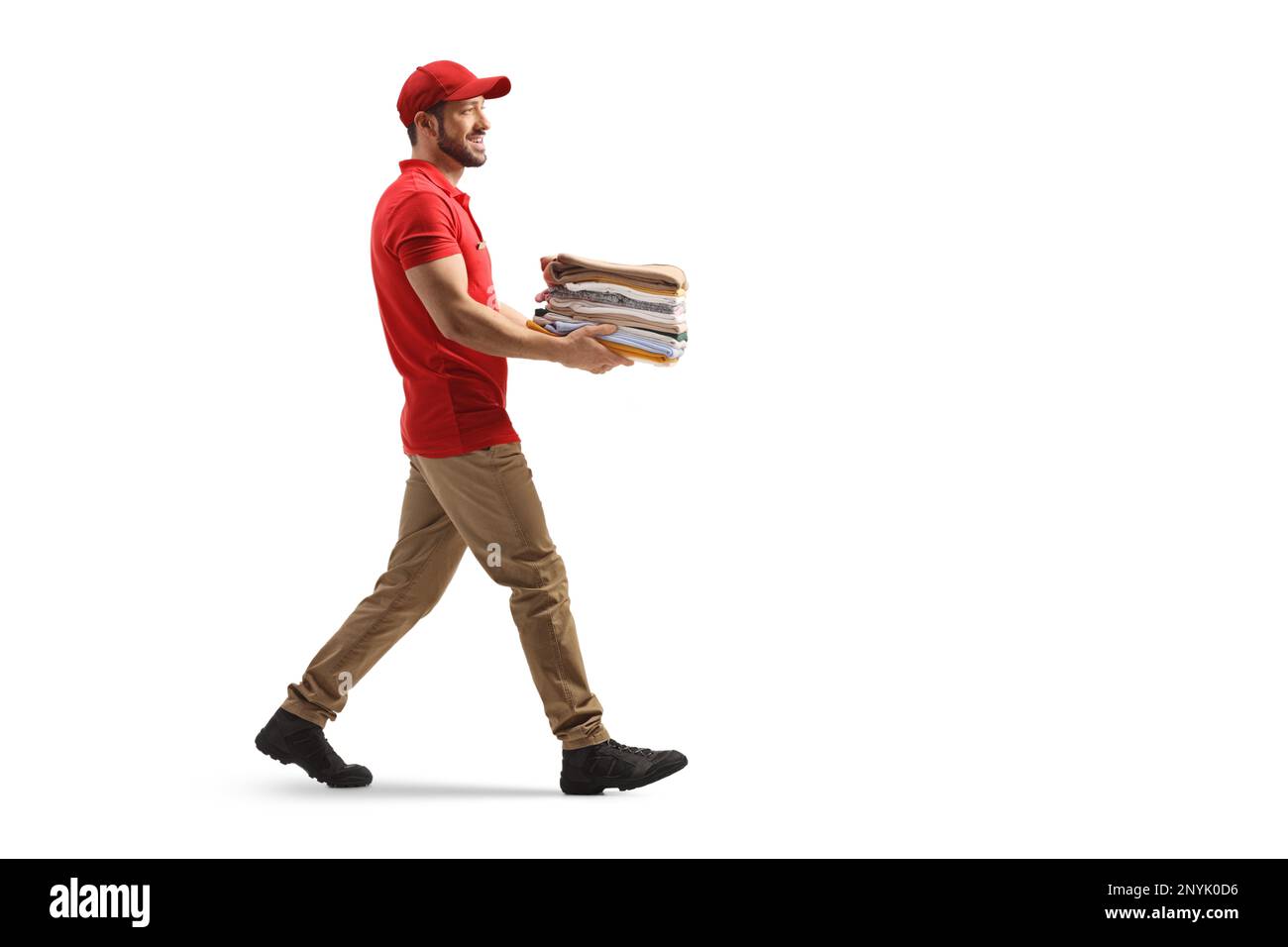 Delivery man carrying a pile of folded clothes and walking isolated on ...