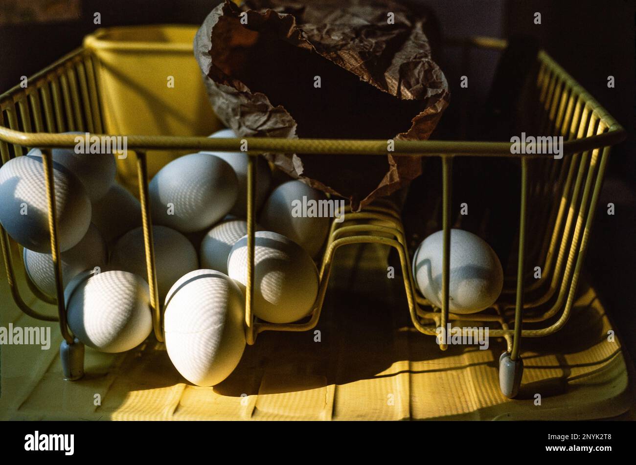 Hard boiled eggs are piled in dish drainer with empty brown paper bag ...