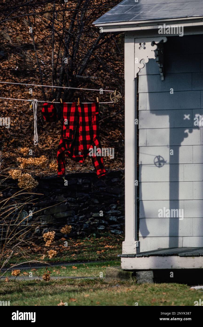 Black and red checkered hunting shirt and cap hang off porch ...