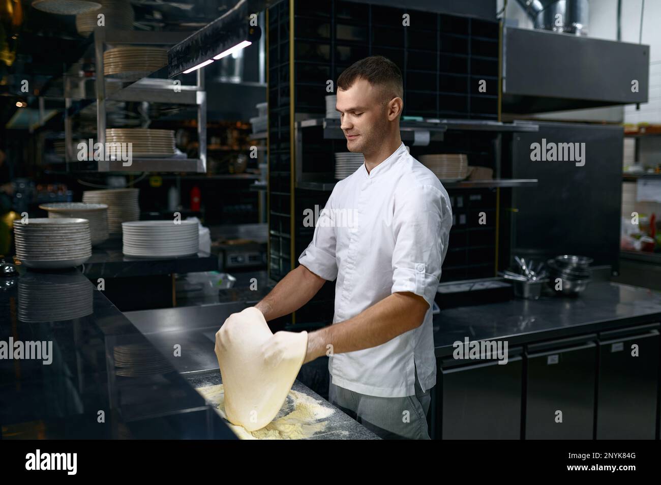 Chef tossing dough in air while making pizza base Stock Photo - Alamy