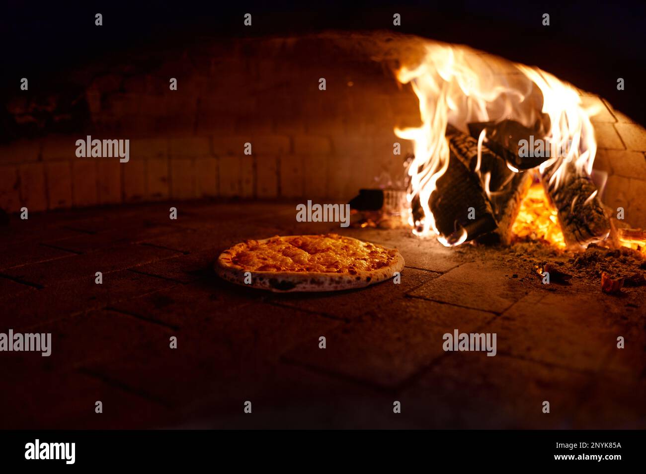 Pizza is cooked in traditional wood oven with open fire Stock Photo - Alamy