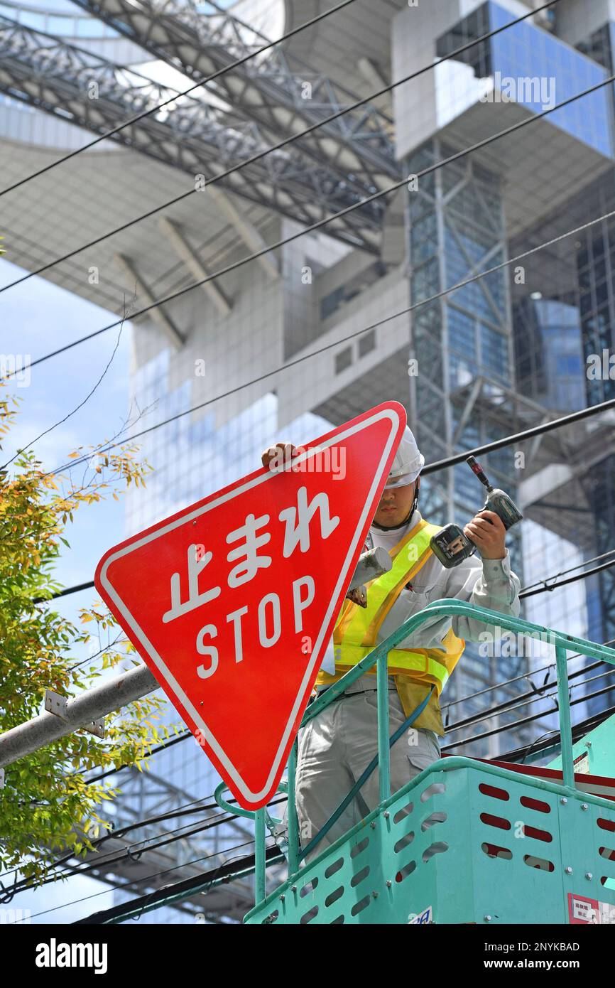 Worker sets up a new road sign in Kita Ward, Osaka on July 1, 2017. The ...