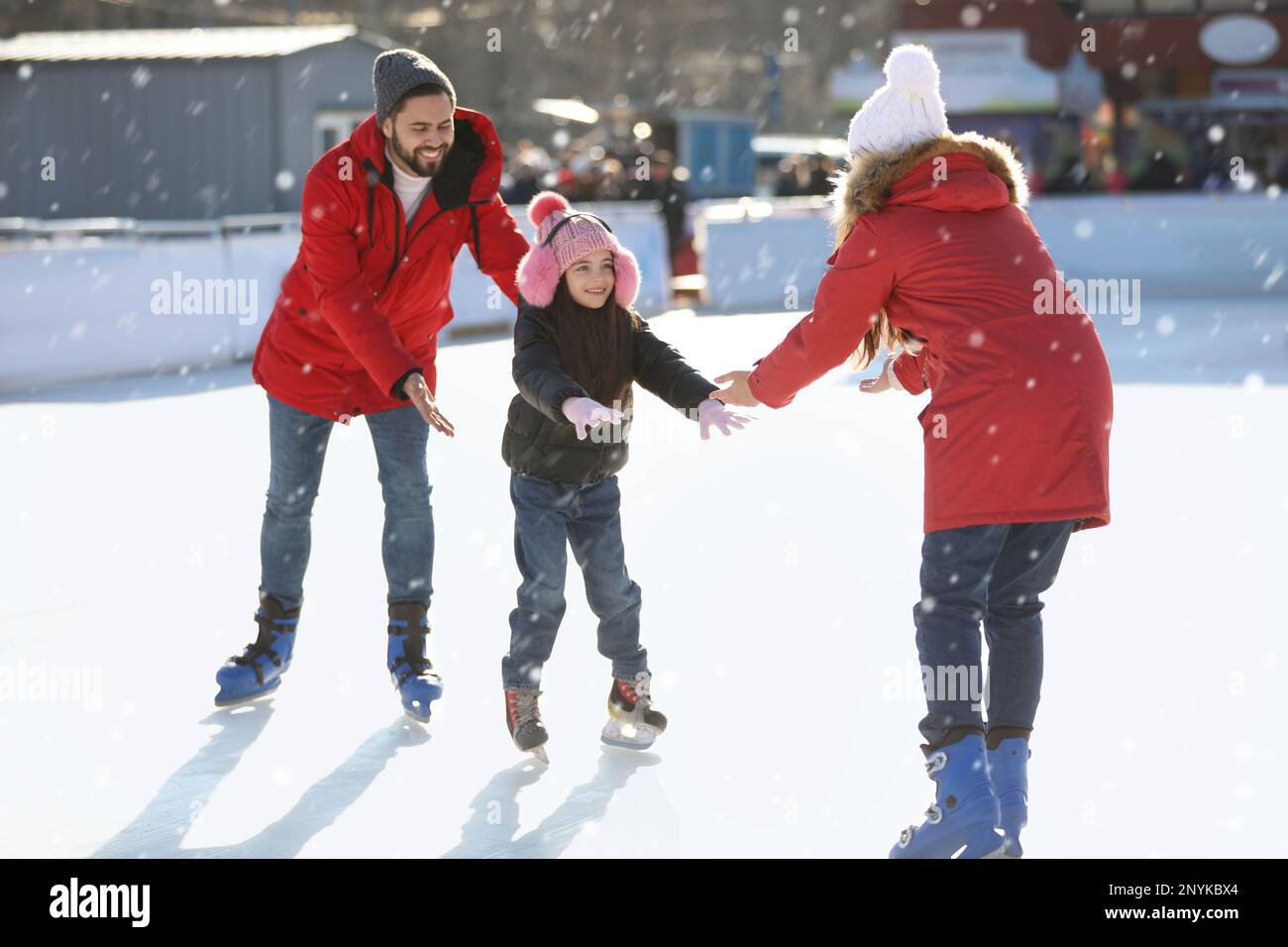 Happy family spending time together at outdoor ice skating rink Stock ...