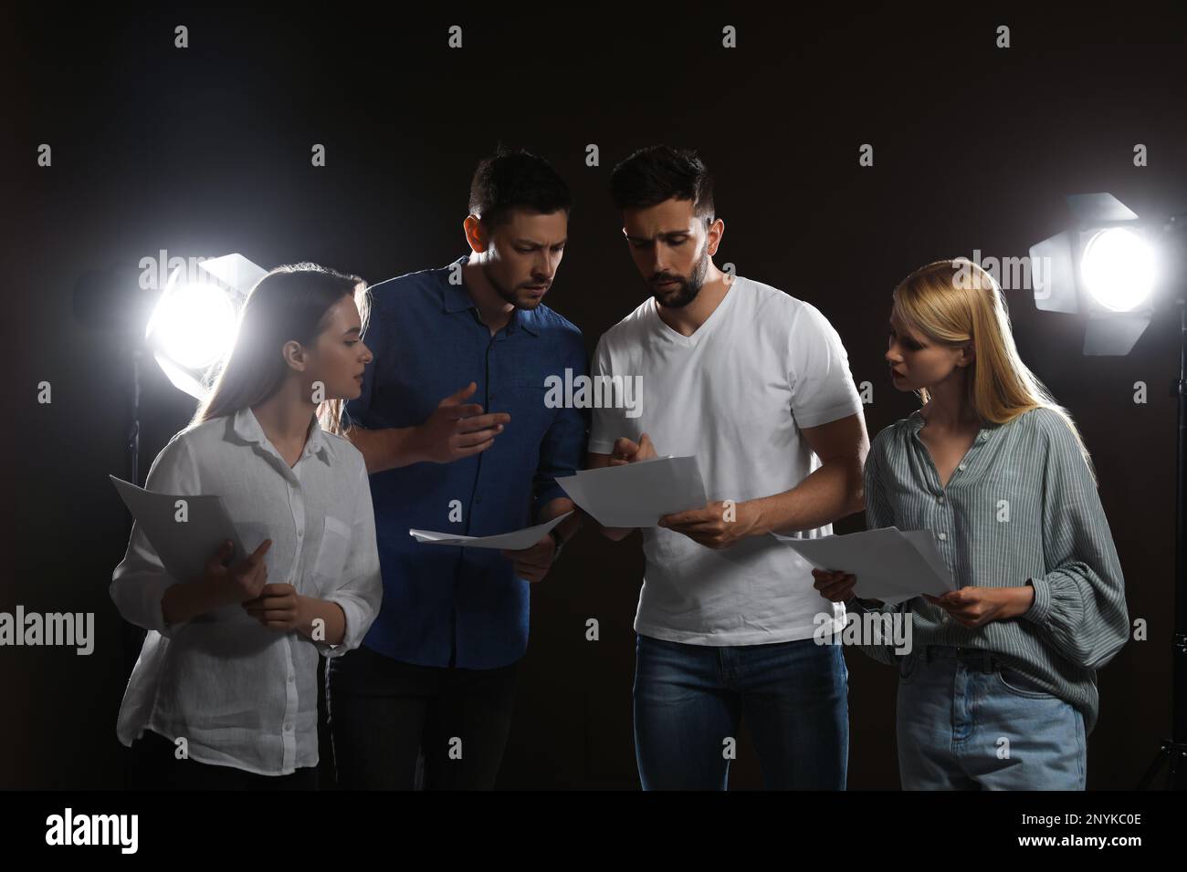 Professional actors reading their scripts during rehearsal in theatre ...
