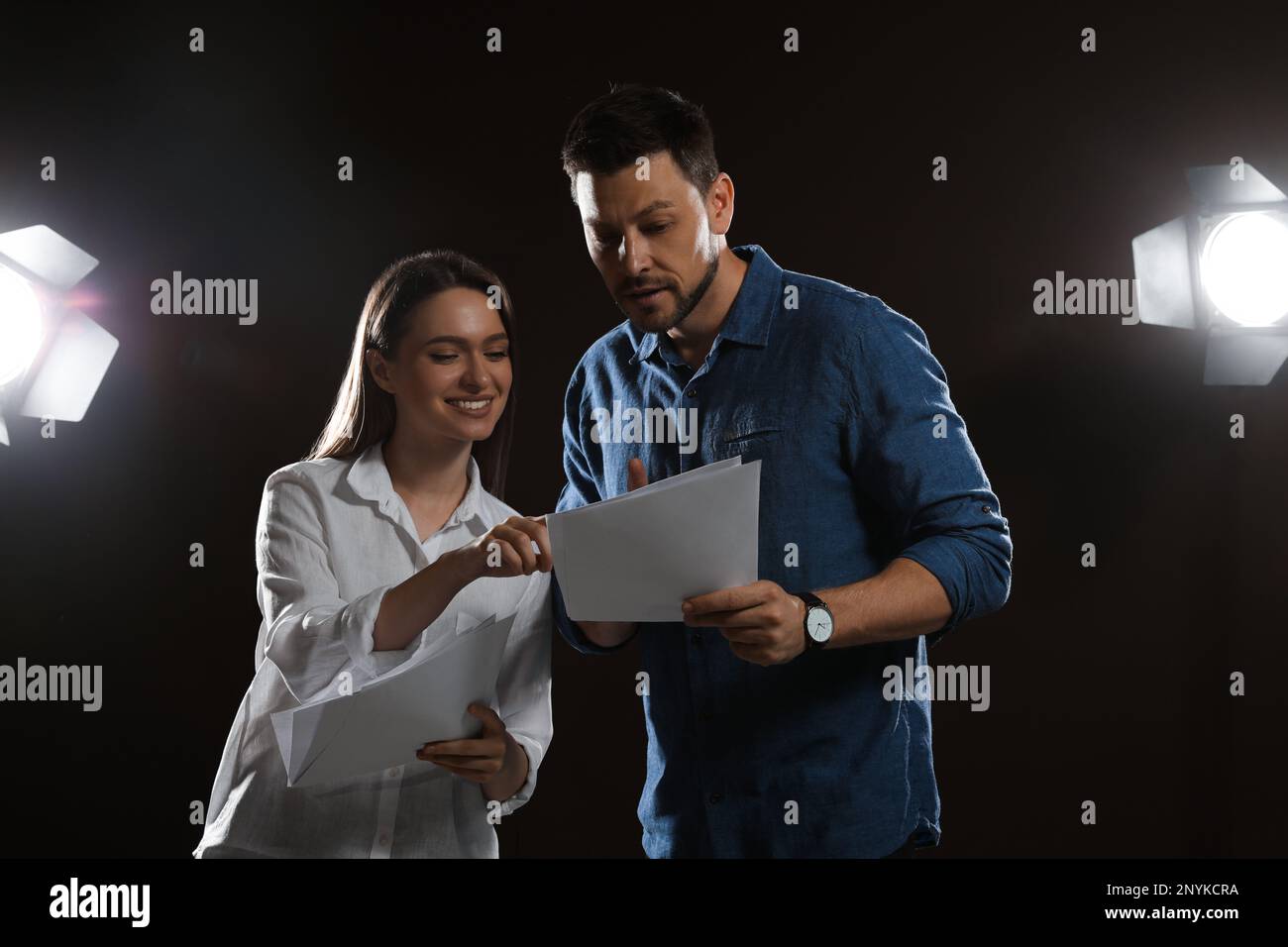 Professional actors reading their scripts during rehearsal in theatre ...