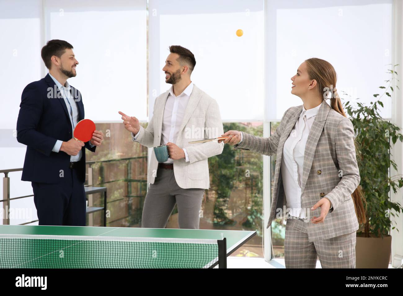 Business people talking near ping pong table in office Stock Photo - Alamy