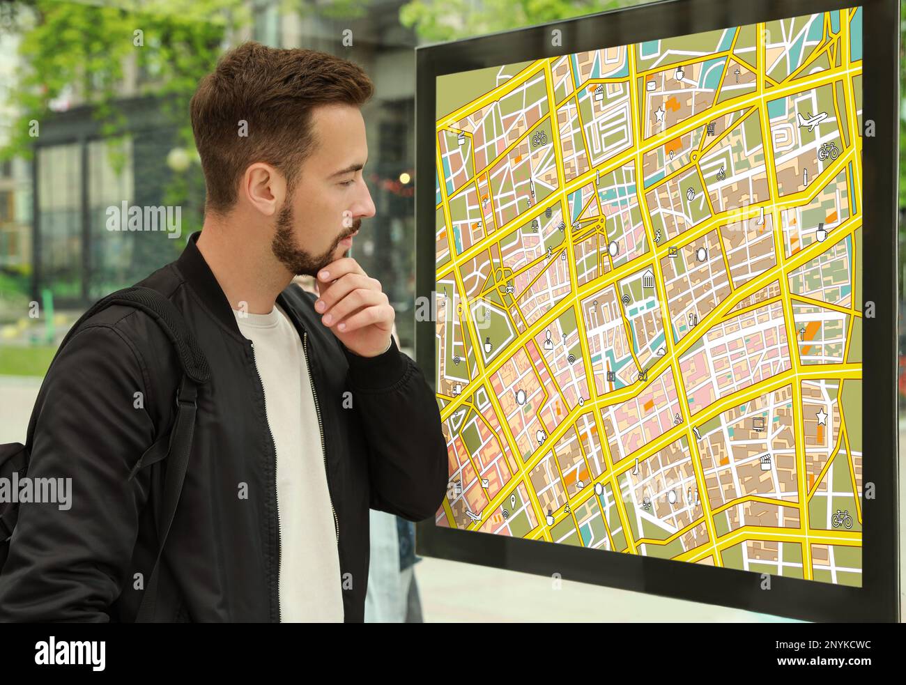 Young man with backpack near public transport map at bus stop Stock ...