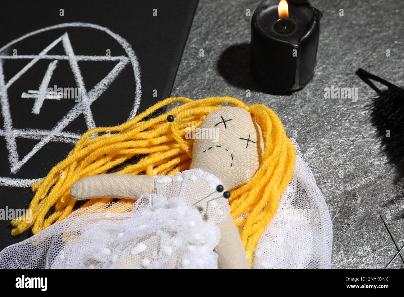 Bride voodoo doll with pins surrounded by ceremonial items on grey ...
