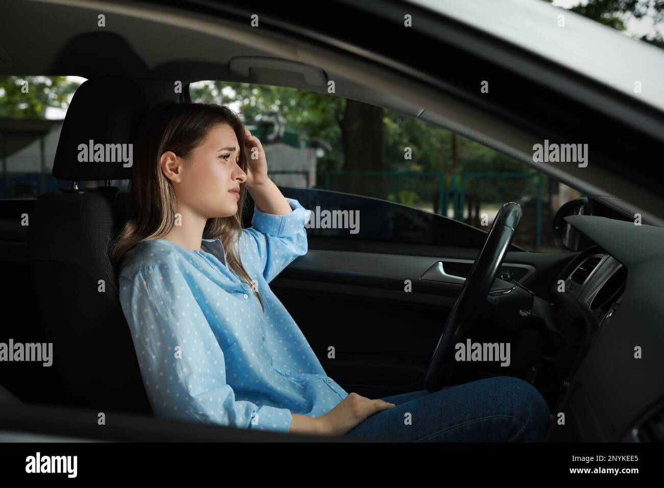 Stressed young woman in driver's seat of modern car Stock Photo - Alamy