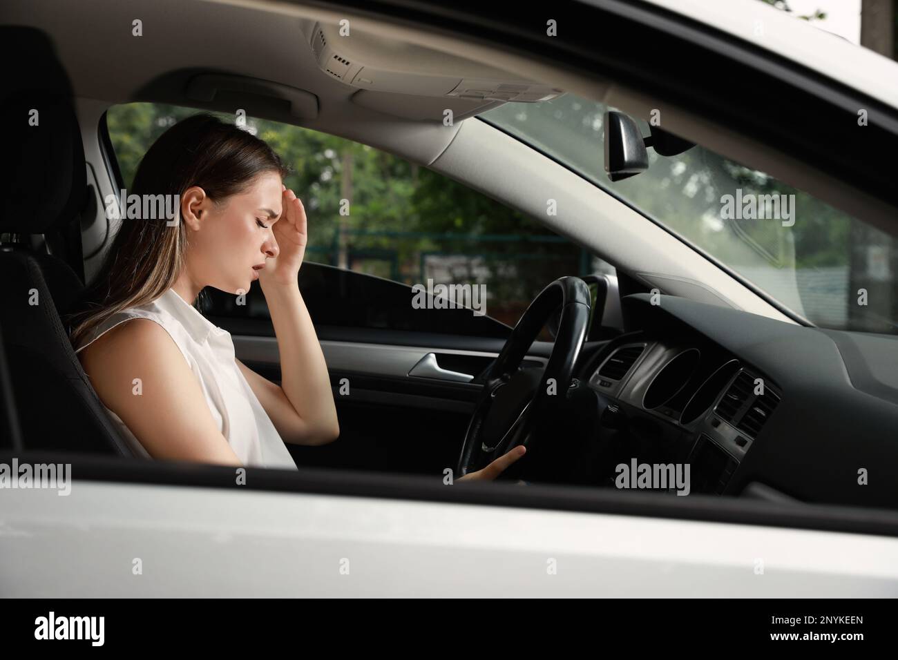 Stressed young woman in driver's seat of modern car Stock Photo - Alamy