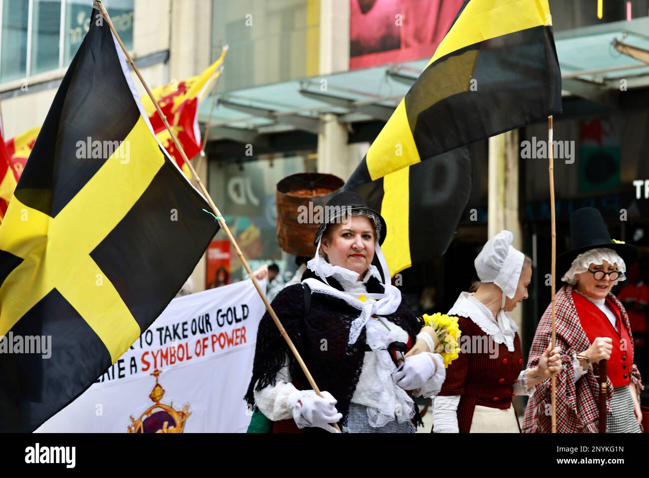 Parade participants hold yellow and black flags during St David's Day ...