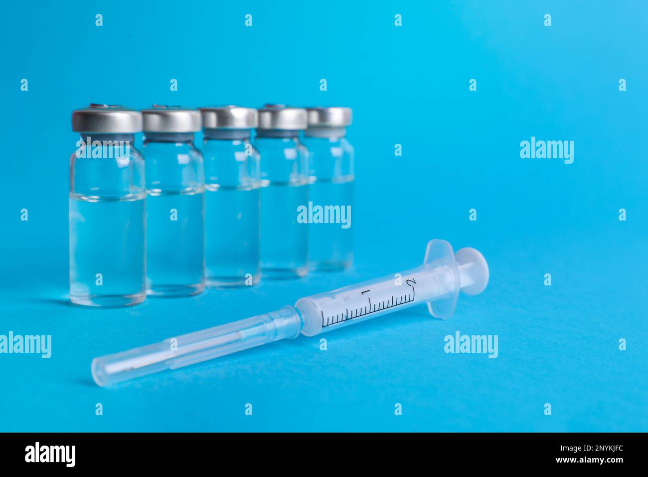 Disposable syringe with needle and vials on light blue background Stock ...