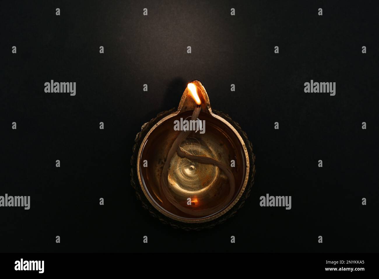 Lit diya on dark background, top view. Diwali lamp Stock Photo - Alamy