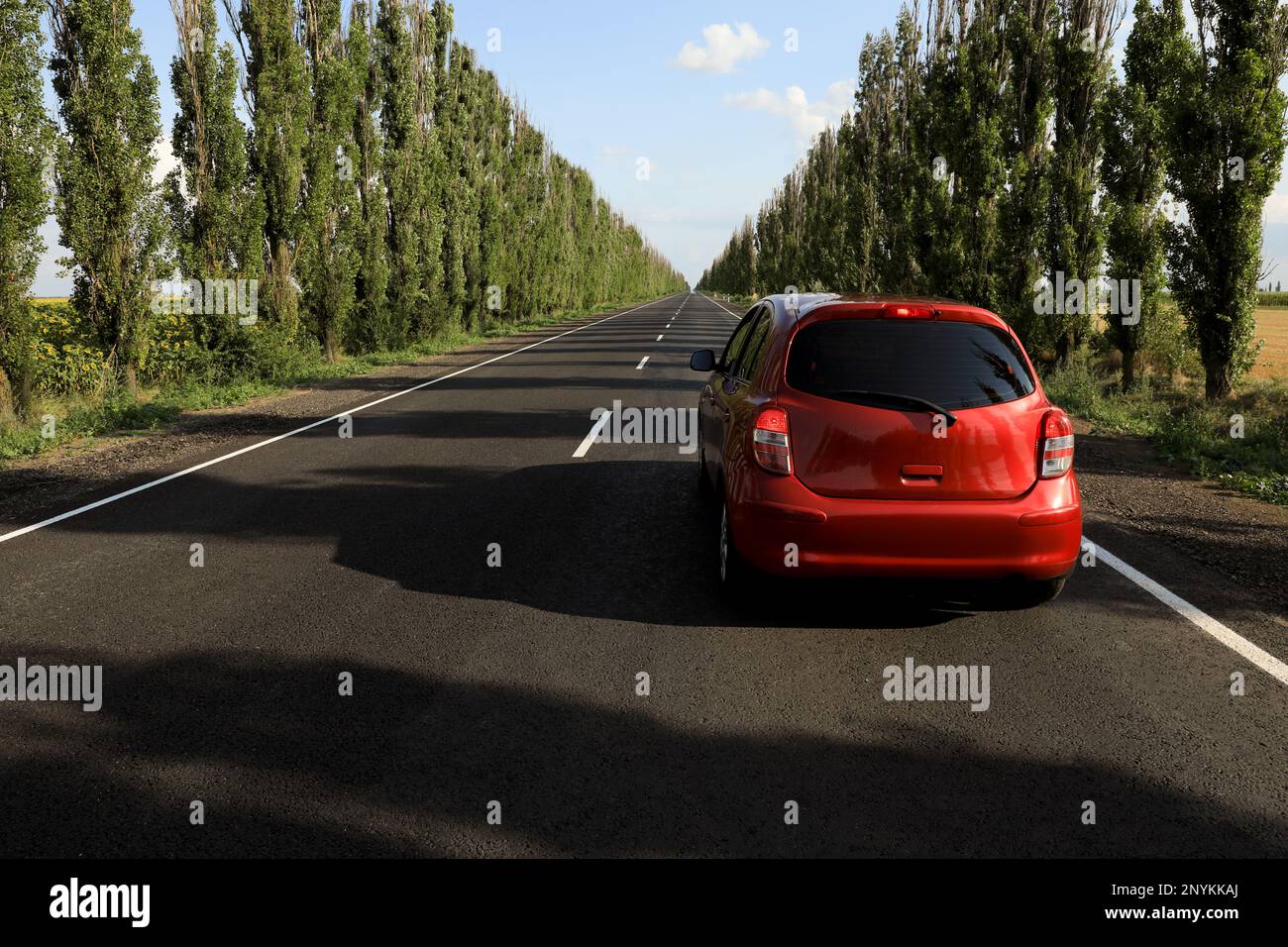 Red car on asphalt road in countryside Stock Photo - Alamy