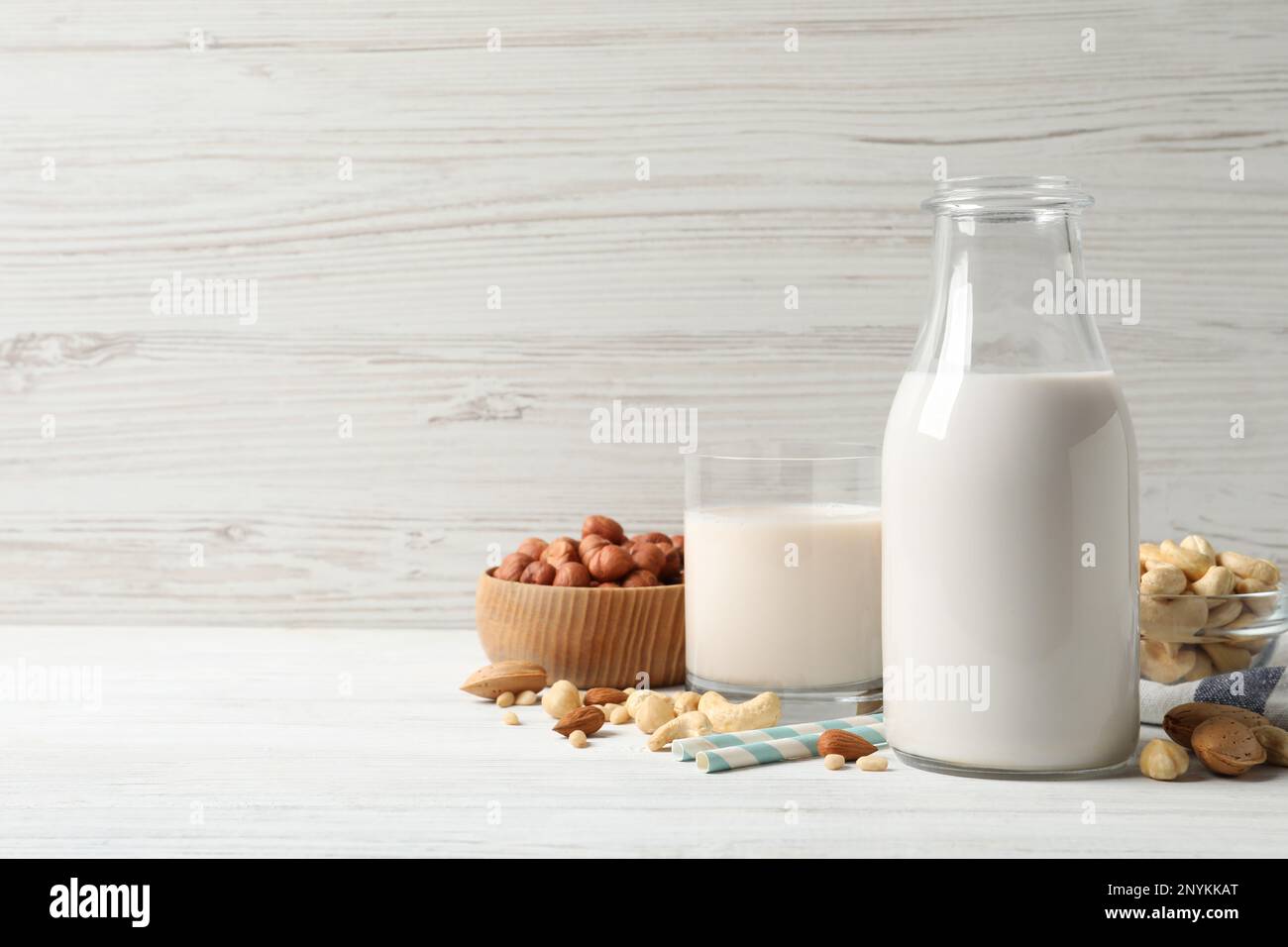 Different nut milks on white wooden table. Space for text Stock Photo ...