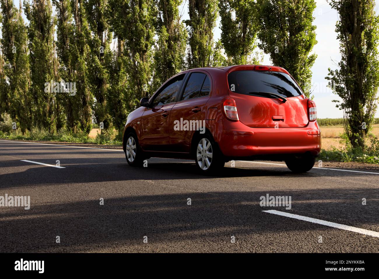 Red car on asphalt road in countryside Stock Photo - Alamy