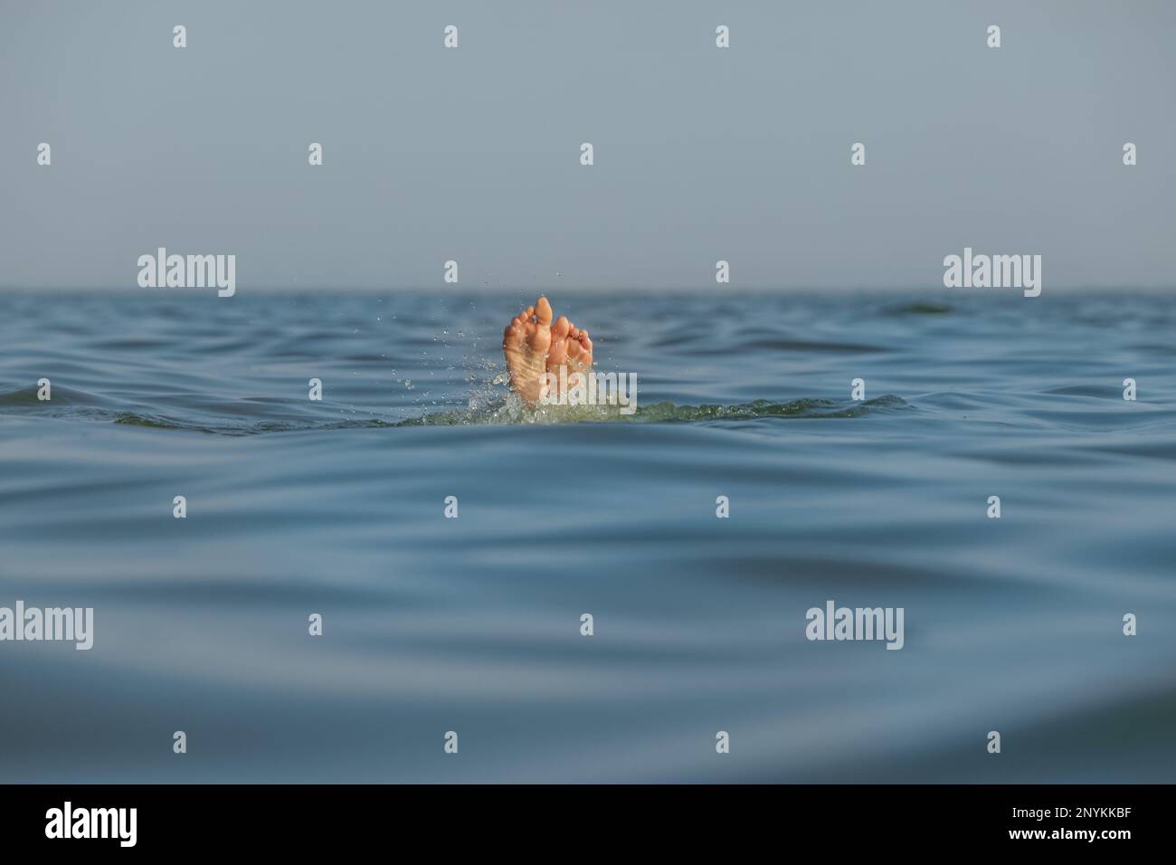 Drowning woman's feet sticking out of sea Stock Photo - Alamy