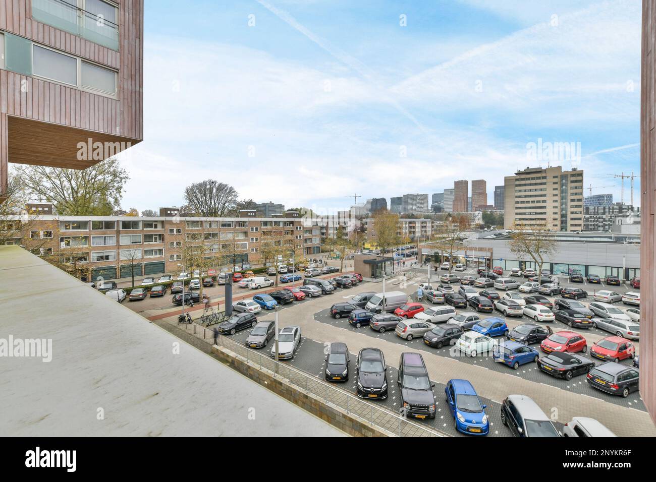 a parking lot with cars parked in it and buildings on the other side of ...