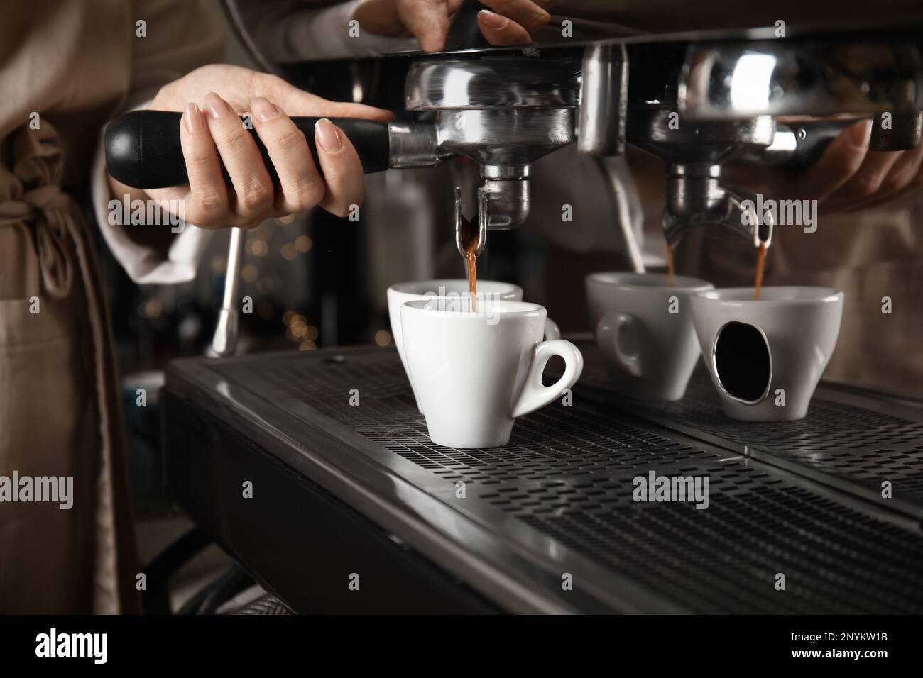 Barista making espresso using professional coffee machine, closeup ...