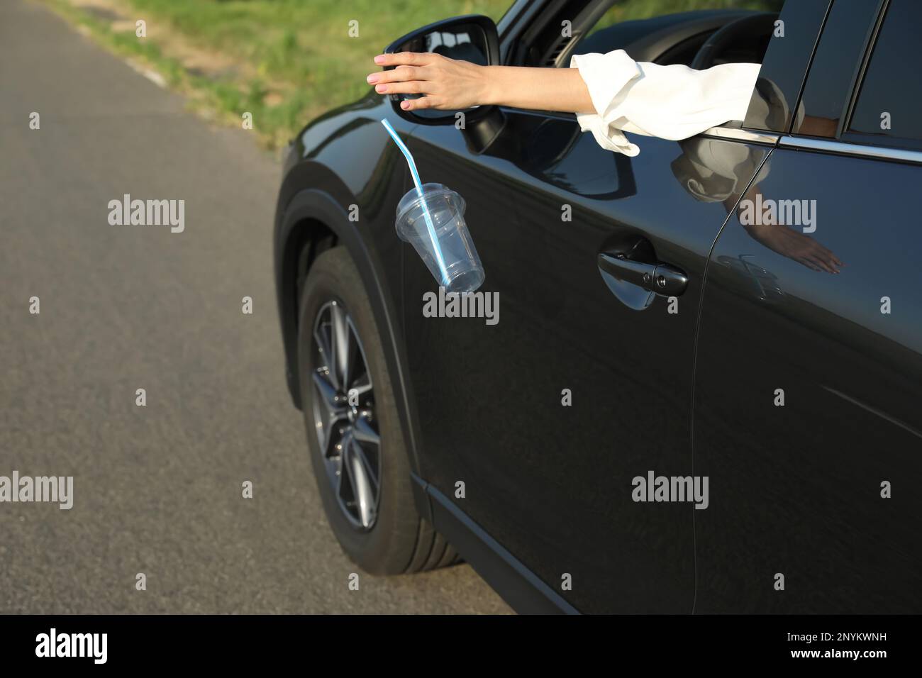 Driver throwing away plastic cup from car window. Garbage on road Stock ...