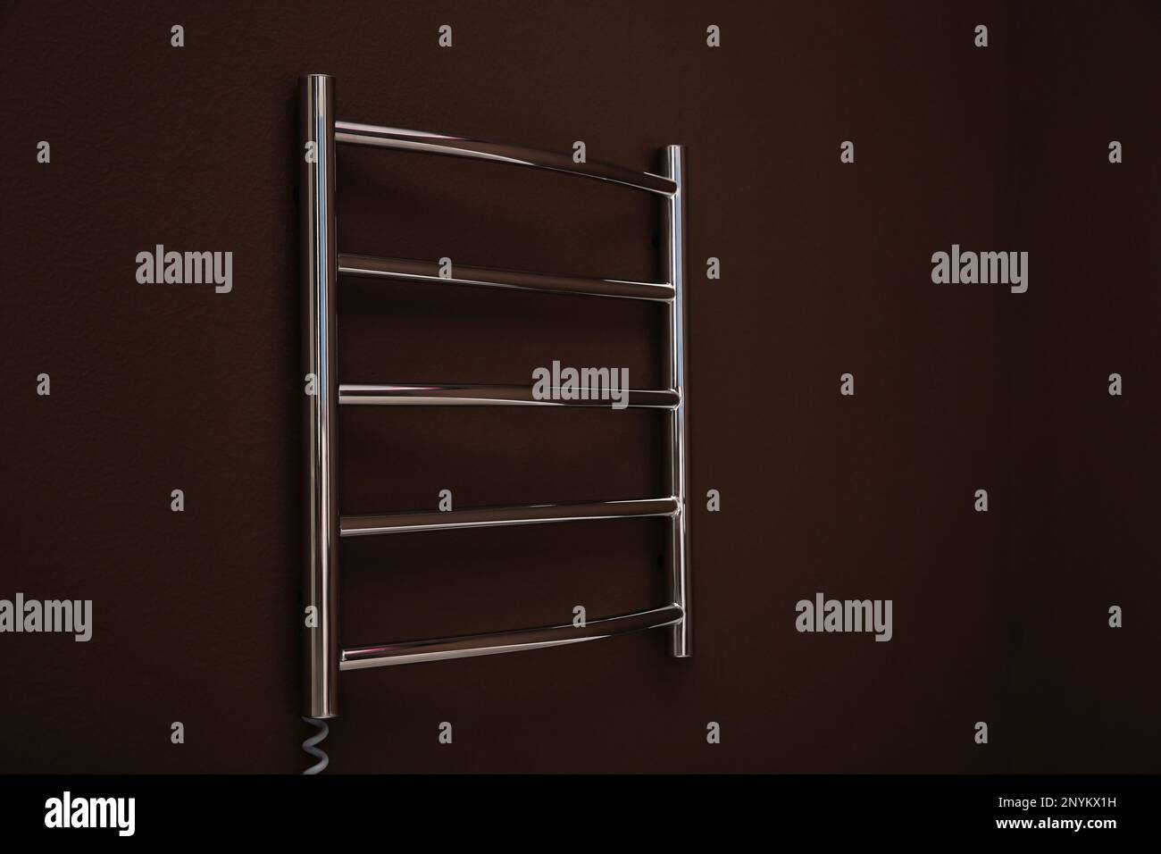 Modern heated towel rail on brown wall. Space for text Stock Photo - Alamy