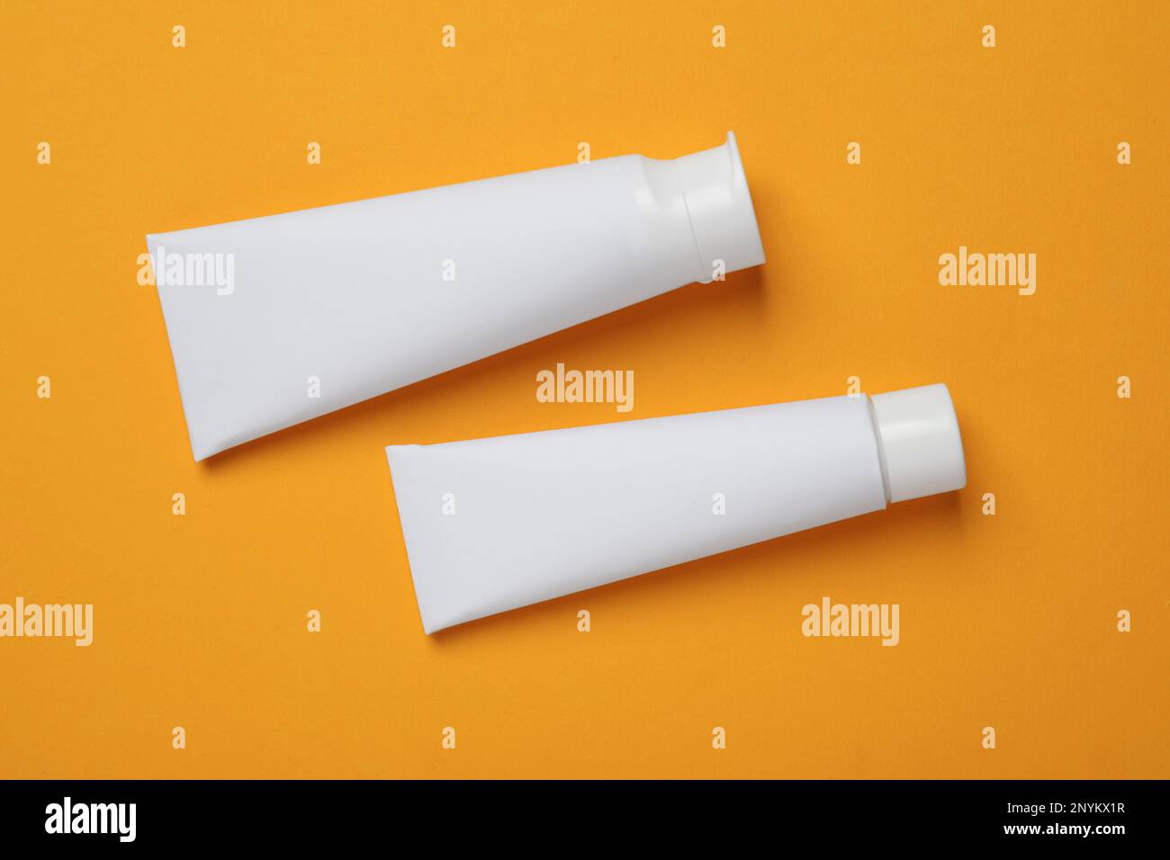Blank tubes of toothpaste on orange background, flat lay Stock Photo ...