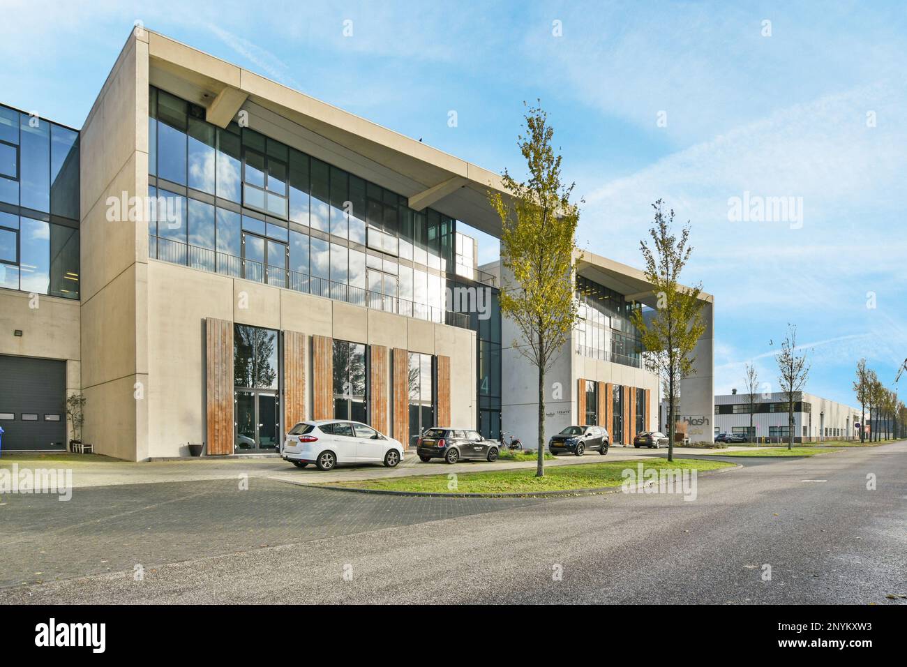 a building with cars parked on the side of the road in front of it and ...