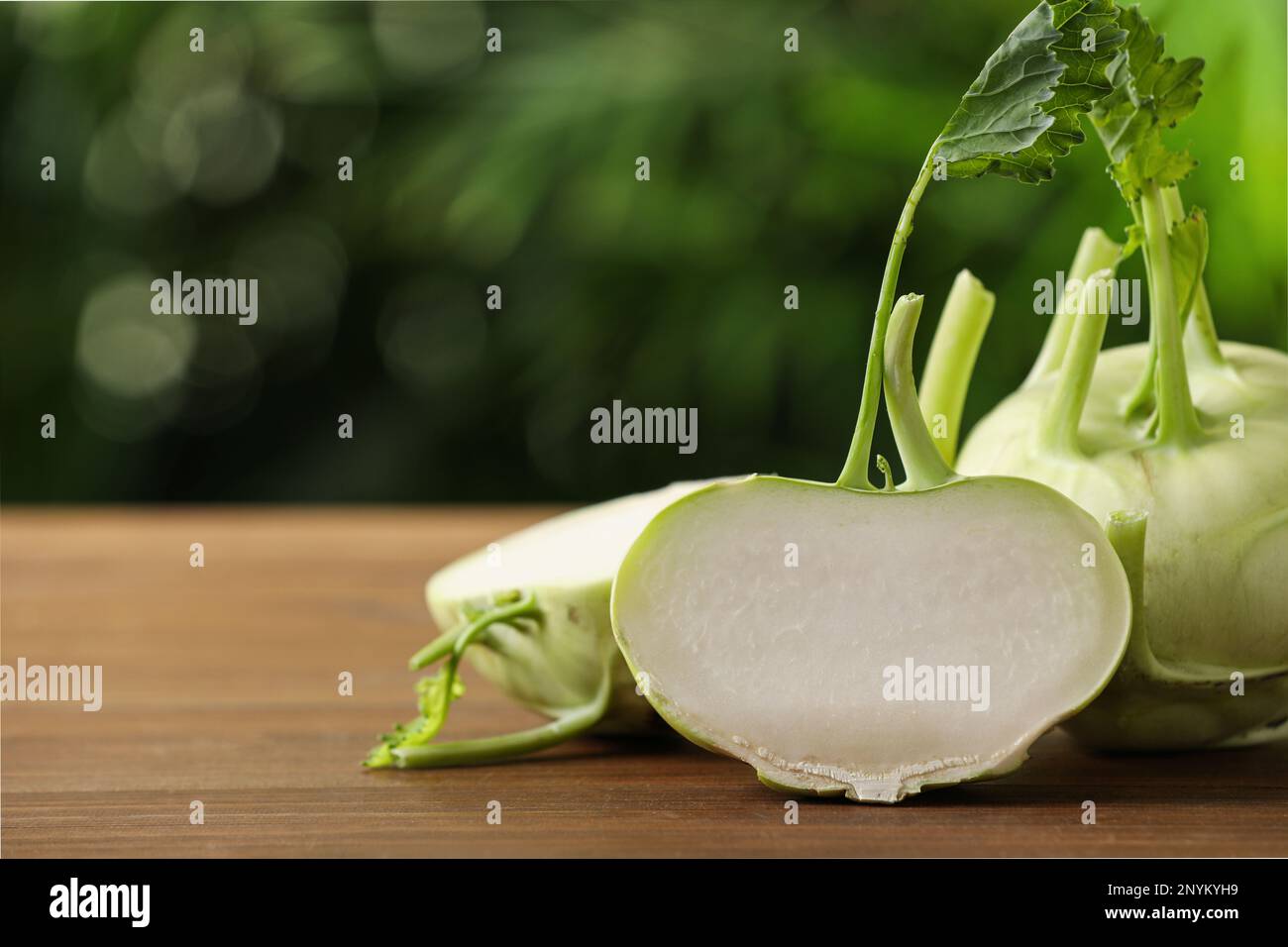 Whole and cut kohlrabi plants on wooden table. Space for text Stock ...