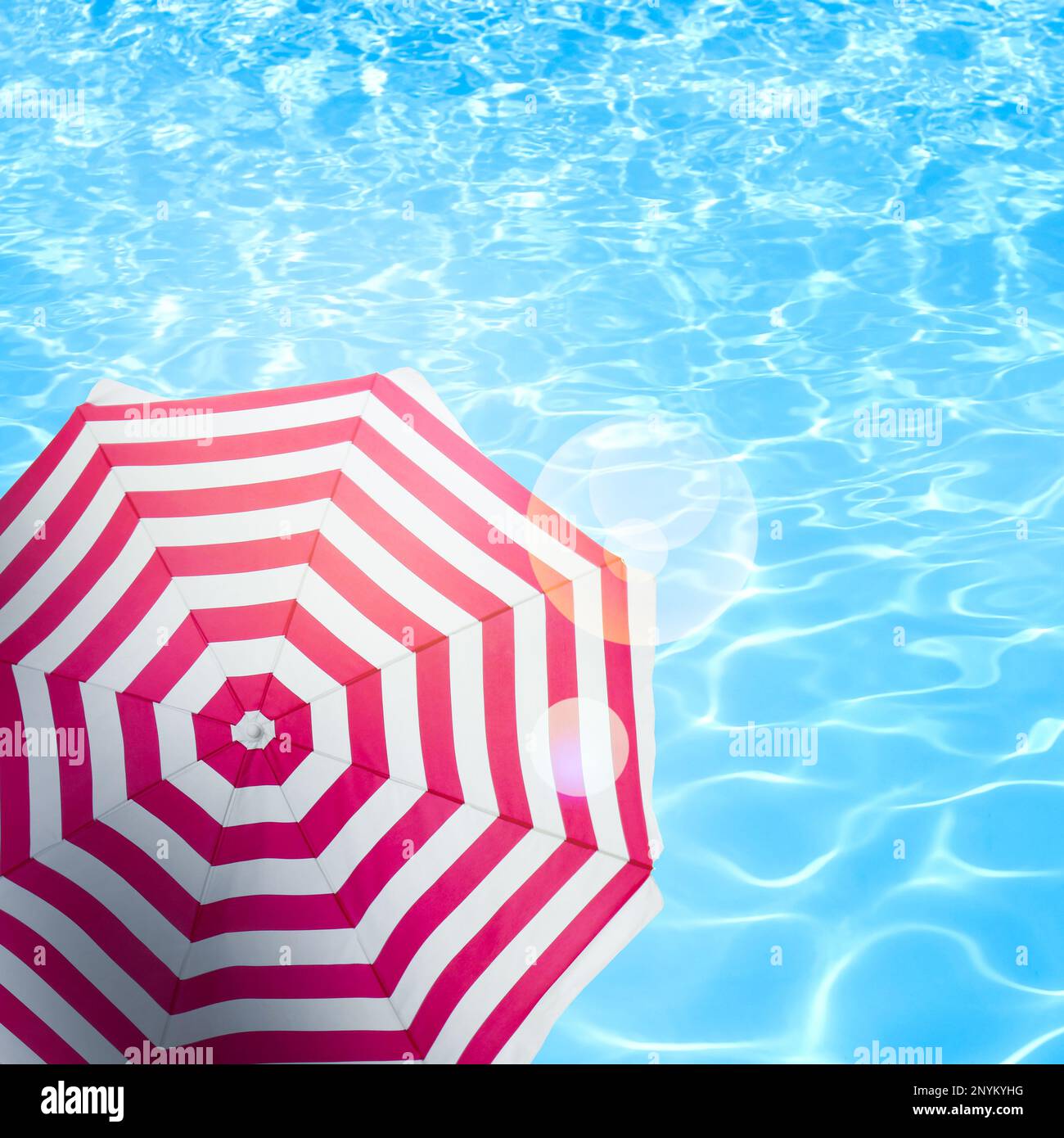Open beach umbrella and swimming pool. Summer vacation Stock Photo - Alamy