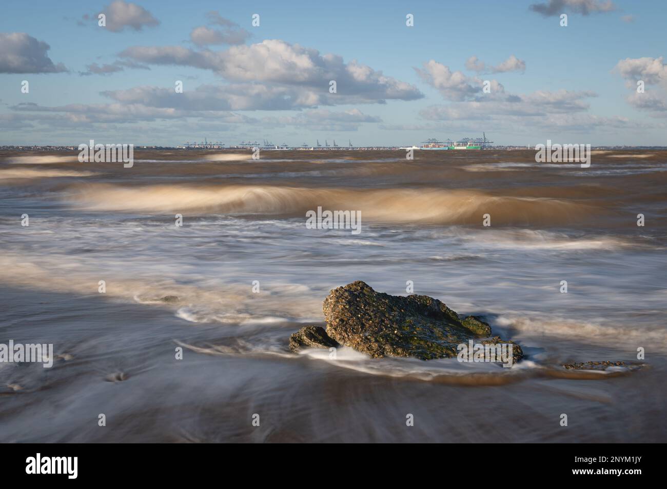 Walton on the Naze beach. View onto Port of Felixtowe. Big rock in the ...