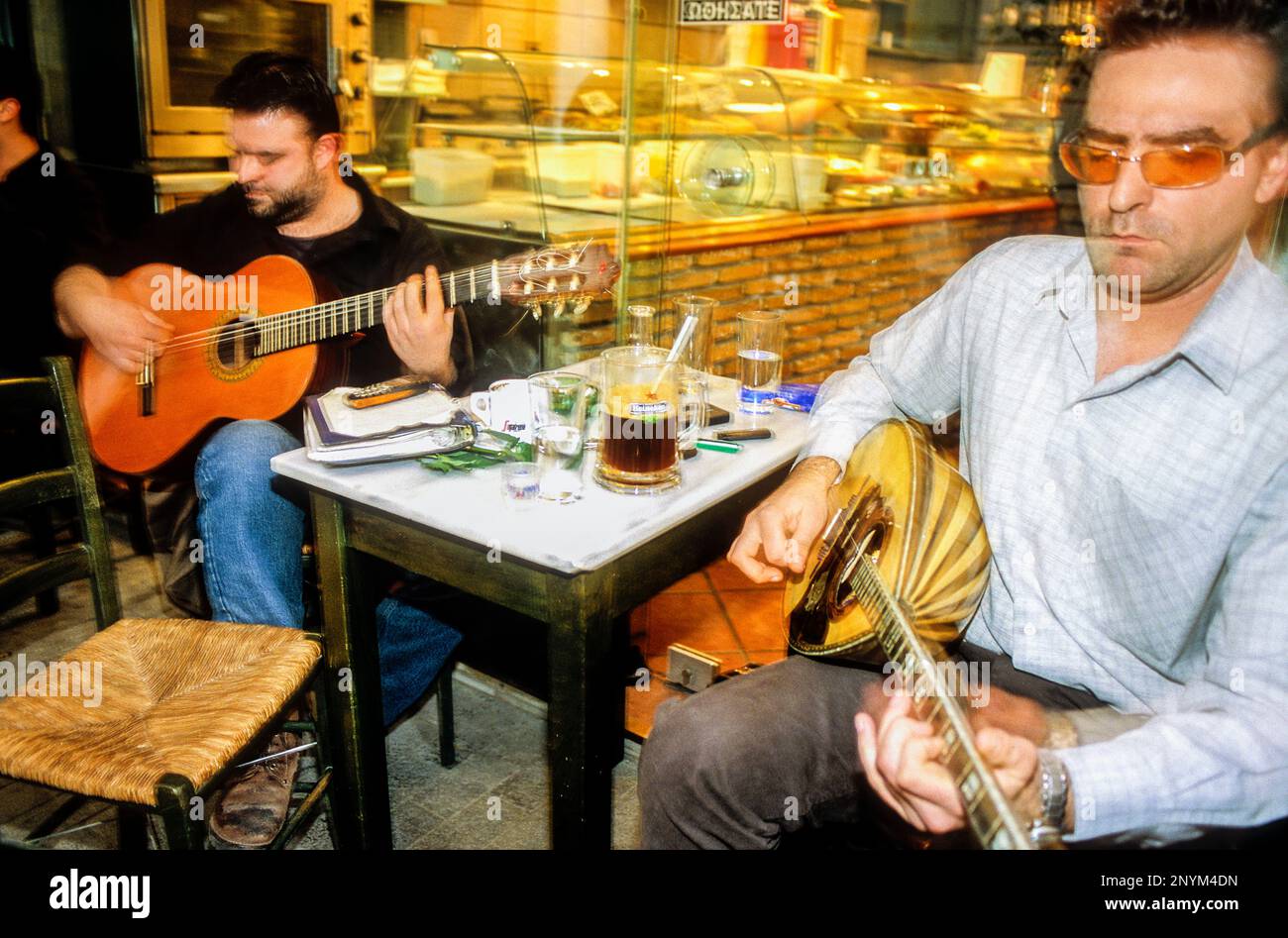 Two friends playing rembetika music in the bar Kapnikarea. In street ...