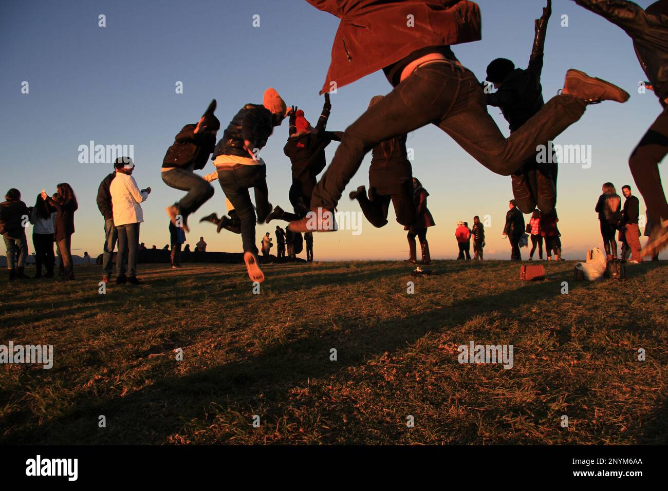 Group of People freeze Jump on the top of a mountain at sunset Stock ...