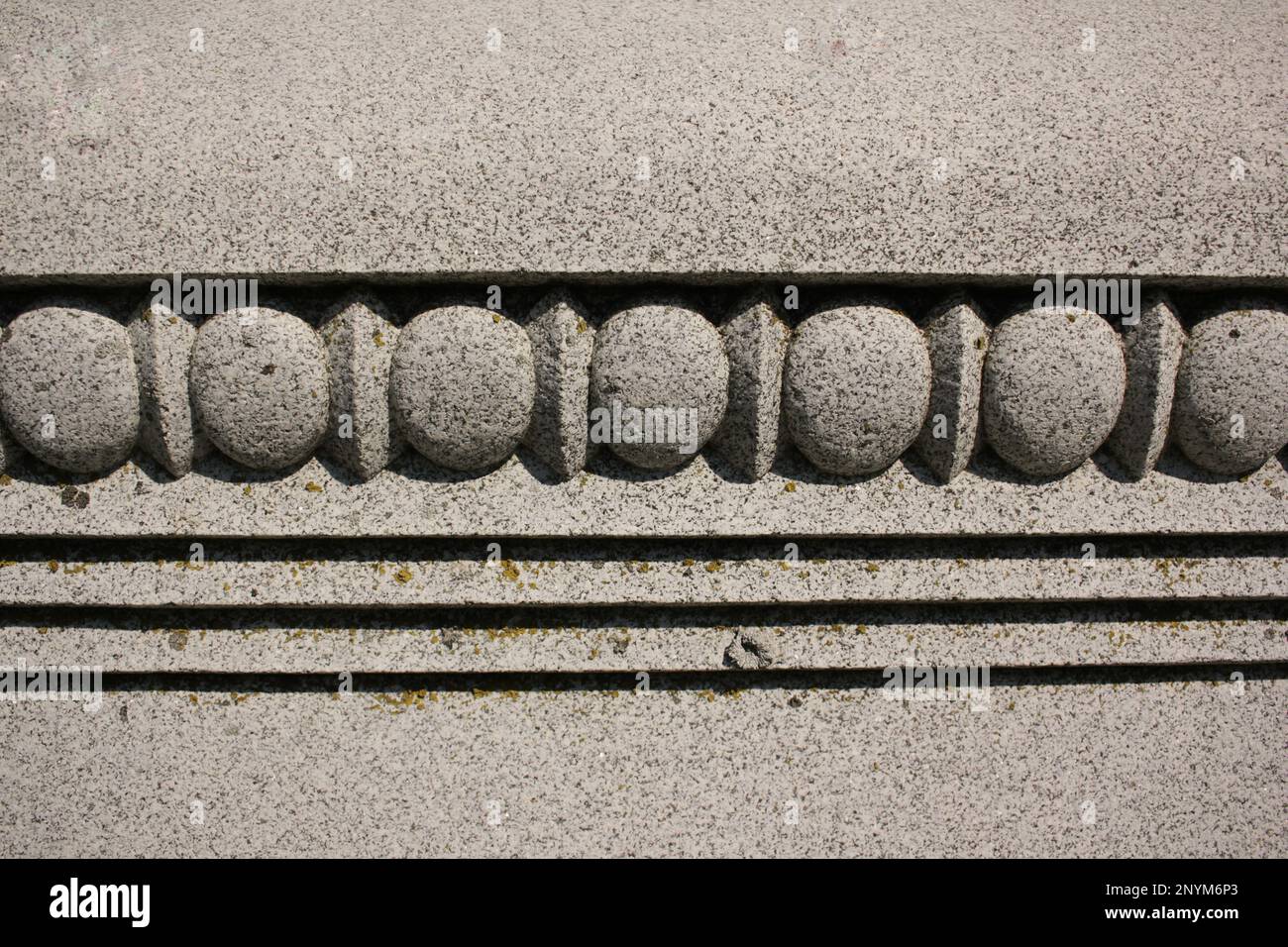 A repeating dot dash pattern carved into the natural stone surface ...