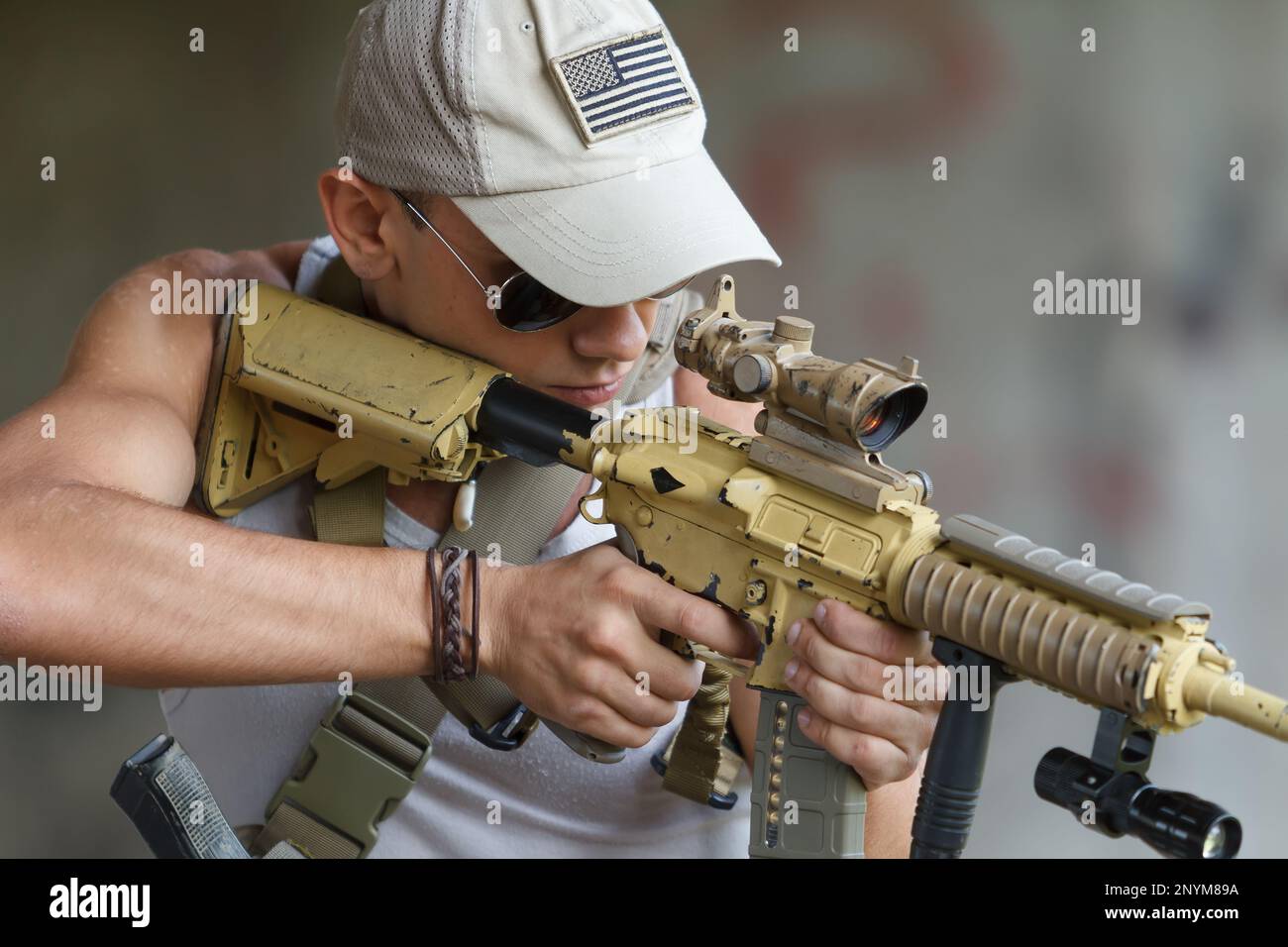 Young Ukrainian soldier aiming with modern assault rifle. Trained white ...