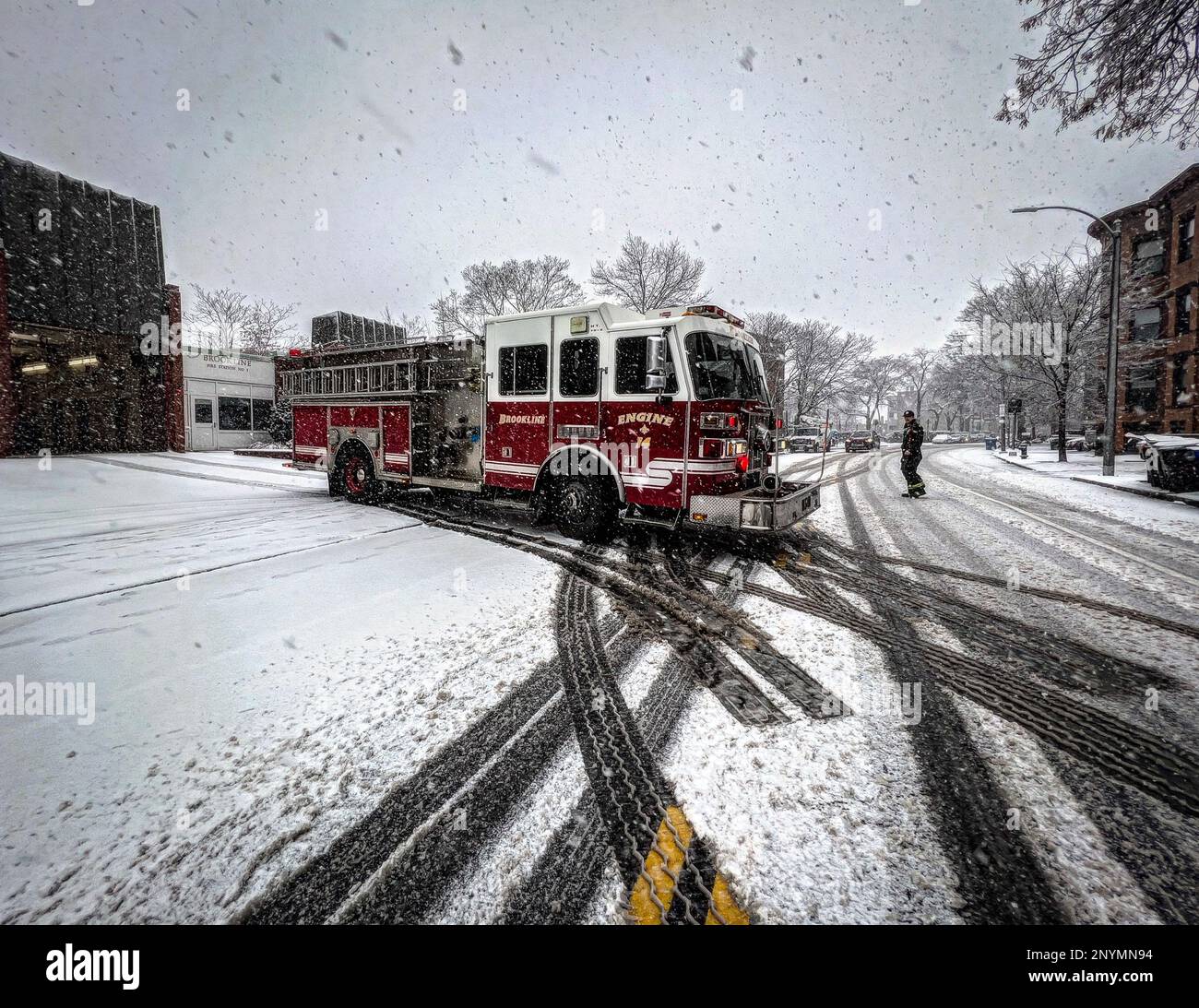 a firetruck driving out of the fire station in a snowy street Stock ...
