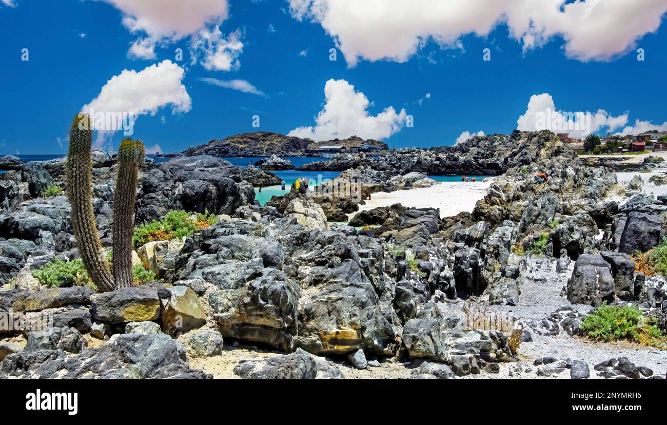 Beautiful secluded white tropical sand beach surrounded by rugged rocky ...