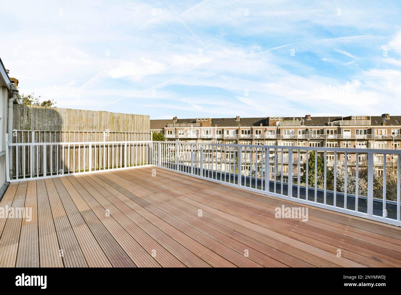 an outside area with wood flooring and white railings on the side of a ...