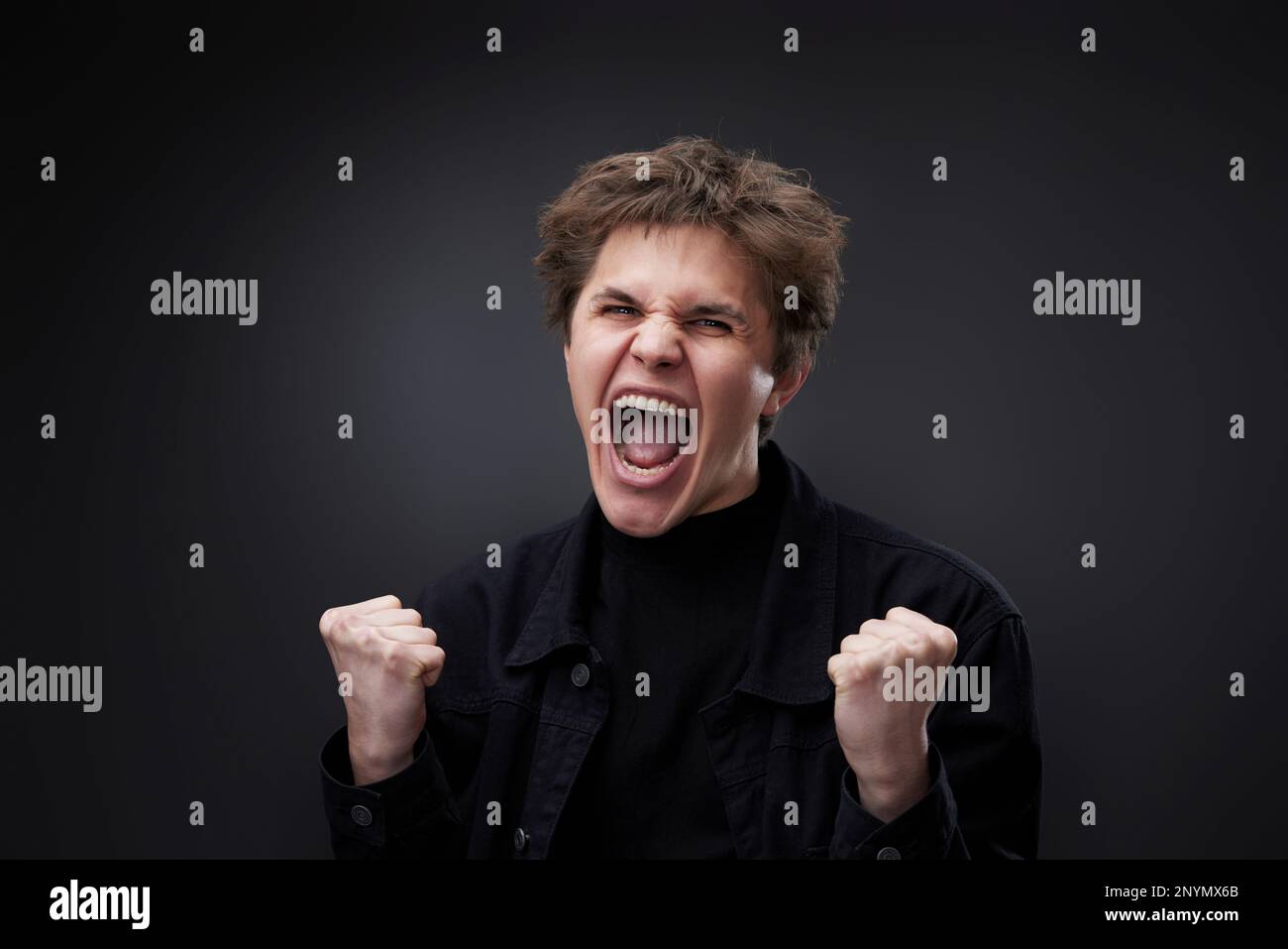 annoyed angry man in furious gesture on black background Stock Photo ...