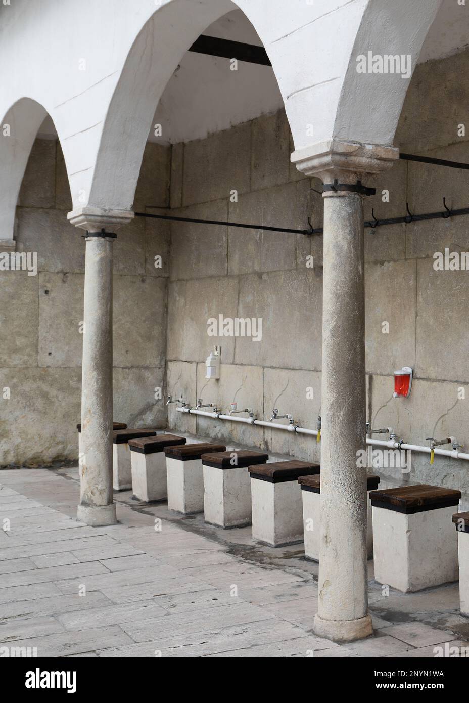 Vertical view of faucets for ritual ablution and chairs to sit on near ...