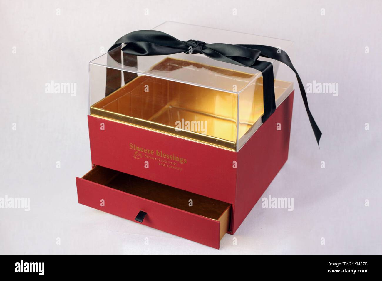 A red and gold gift box with a black bow and an opening door Stock ...