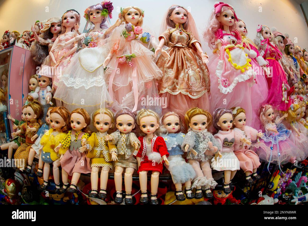 Dolls on the shelf on display for sale dressed in dresses of all colors ...