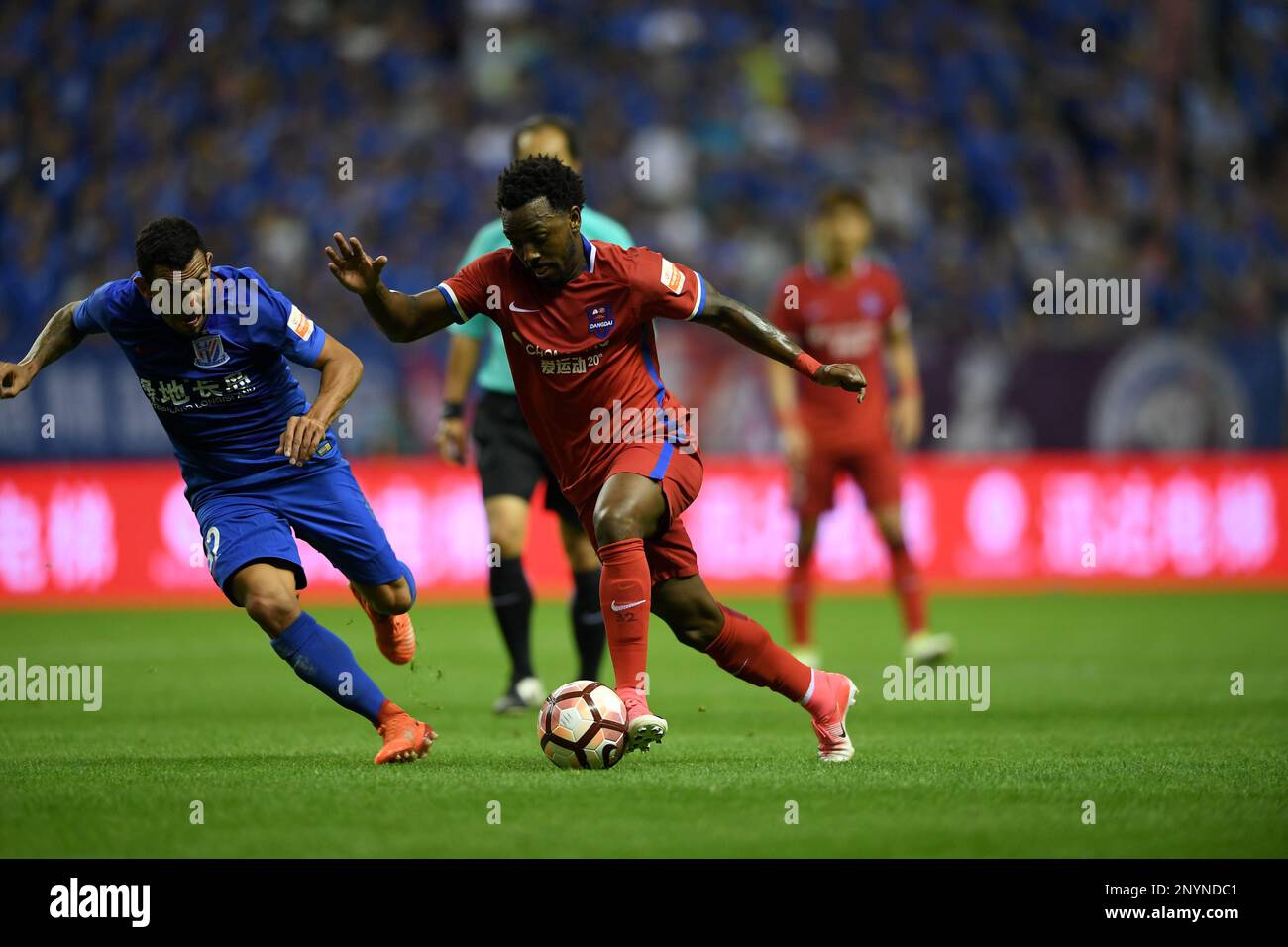 Brazilian football player Fernandinho, right, of Chongqing Lifan kicks ...