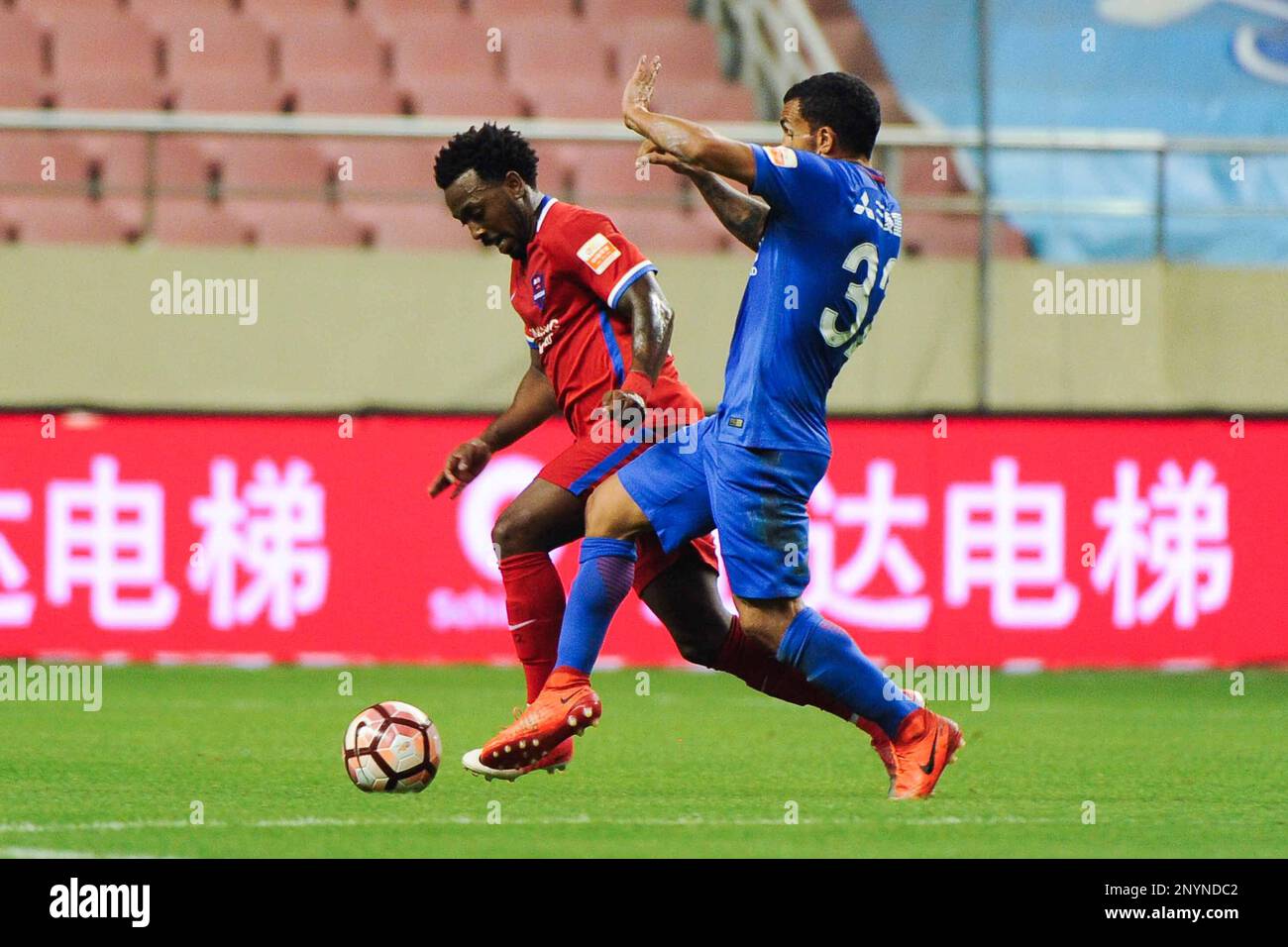 Brazilian football player Fernandinho, left, of Chongqing Lifan kicks ...