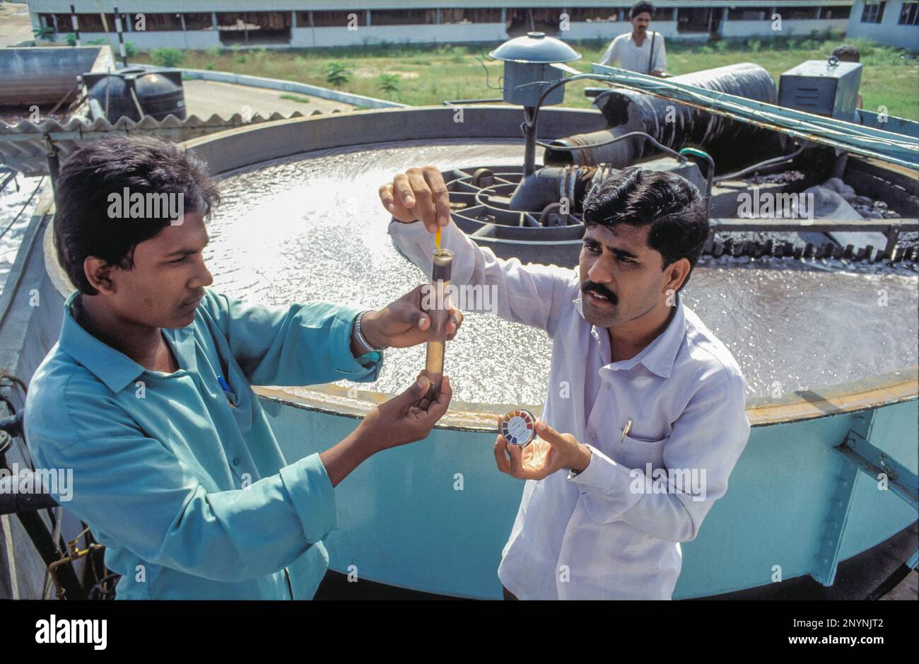 India, Madras. Two men are testing the water treatment of a tannery ...
