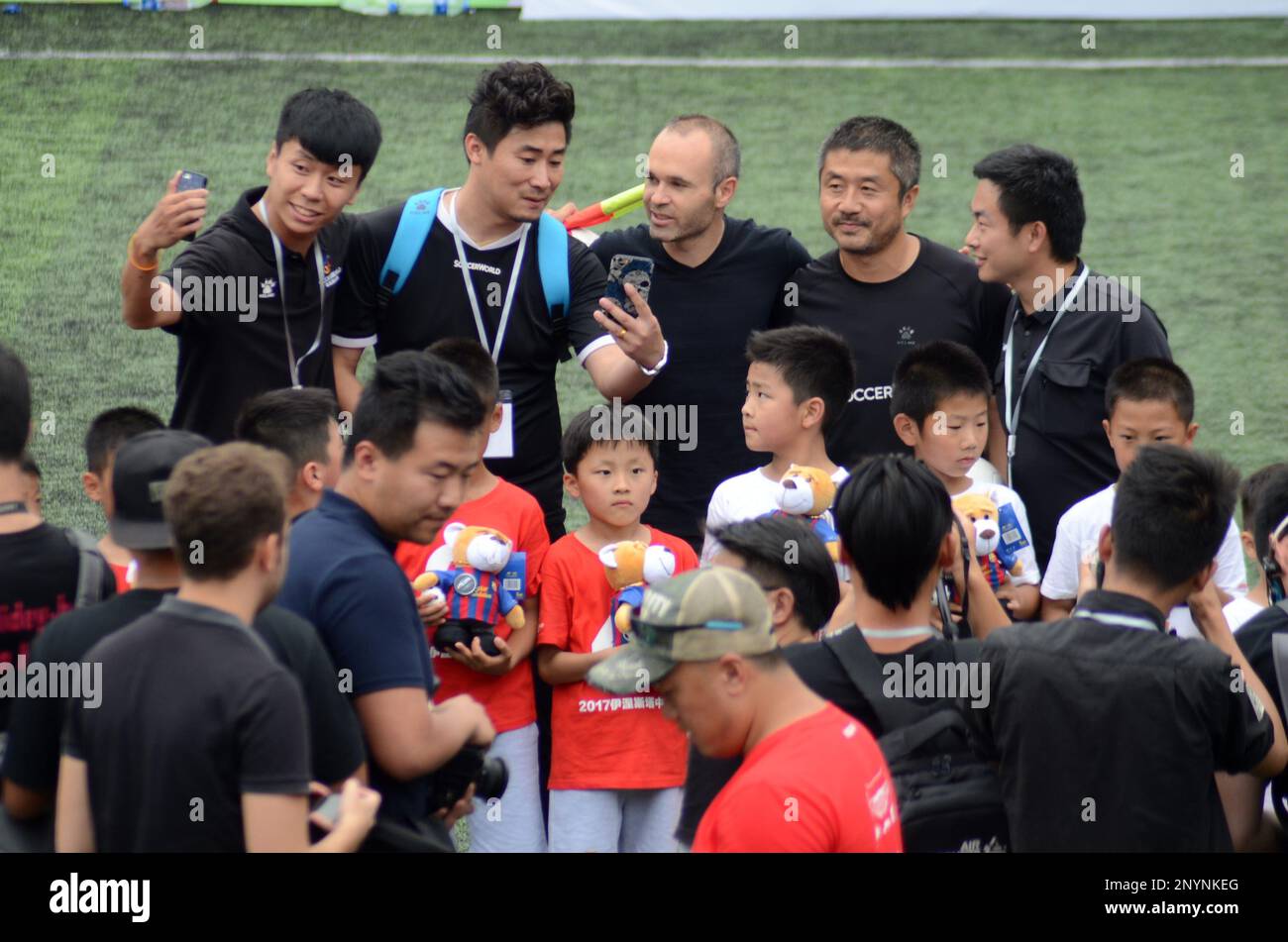 Spanish football player Andres Iniesta, center, takes selfies with fans ...
