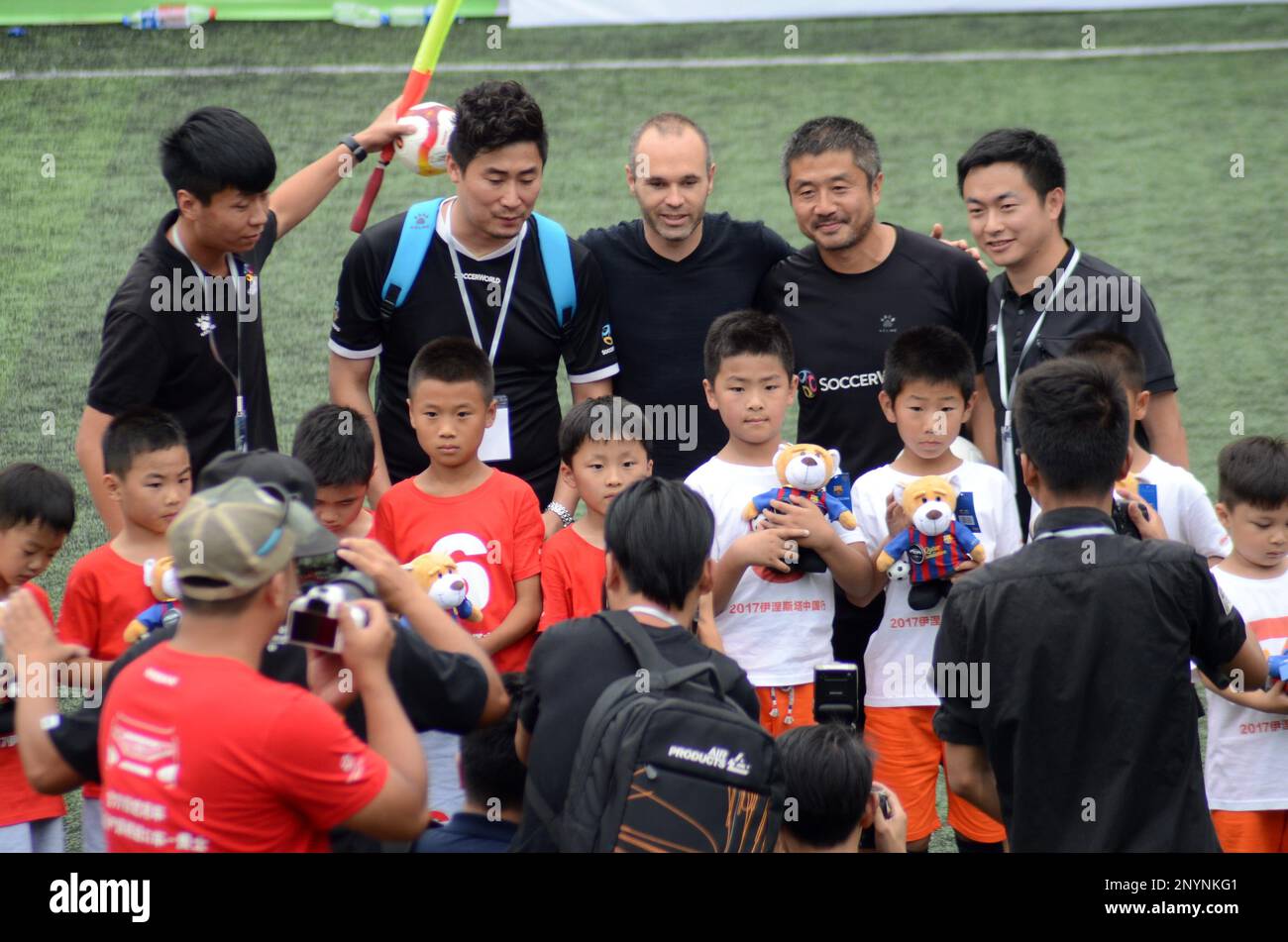 Spanish football player Andres Iniesta, center, takes selfies with fans ...