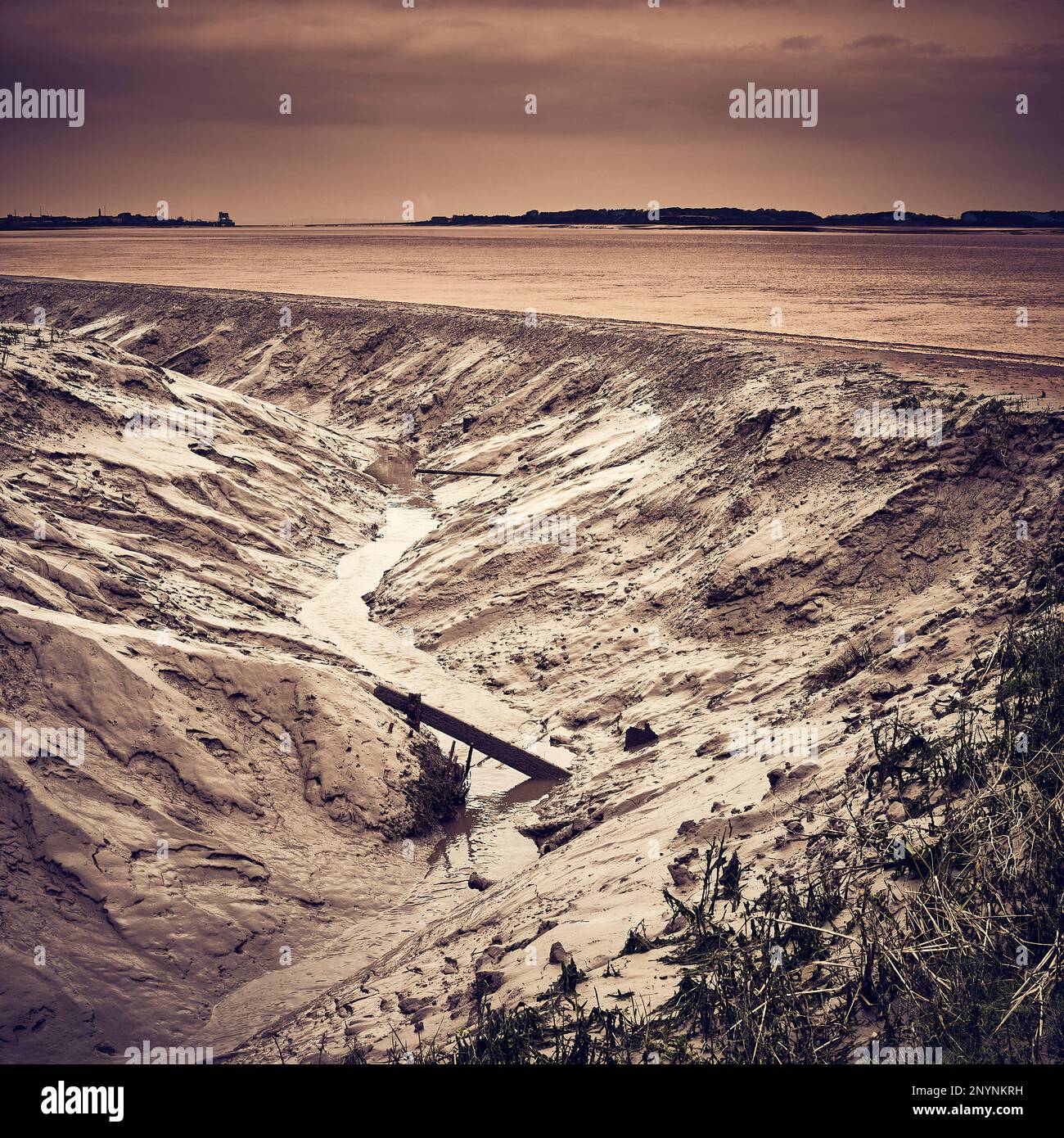 Old broken wooden structure over stream through mudbank Stock Photo - Alamy