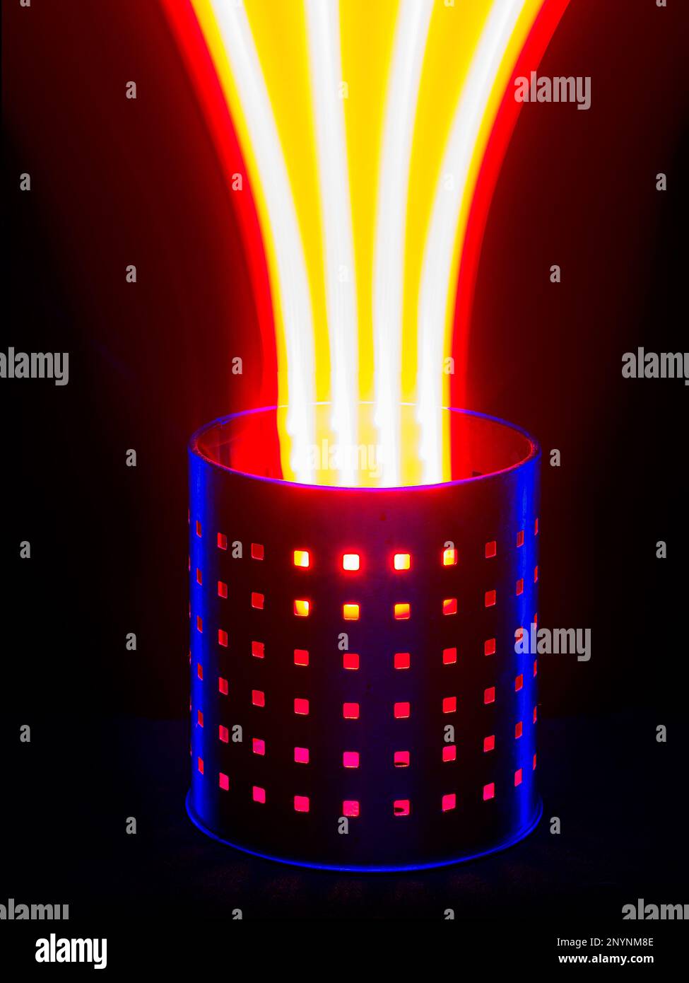 Bright light source erupts from metal lamp on dark background. Magic ...